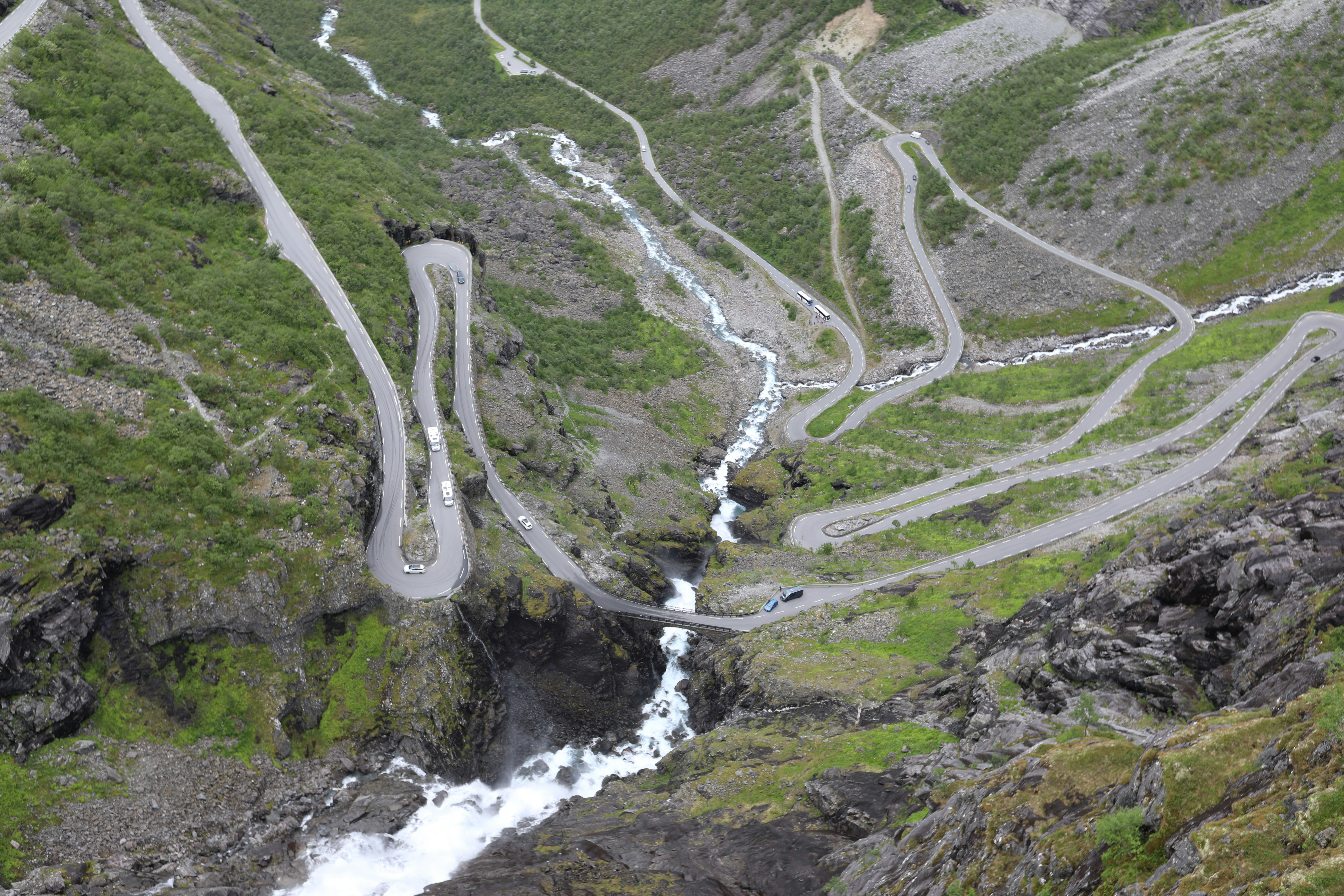 Trollstigen, Norway | Winding road ascends a mountain with a waterfall.