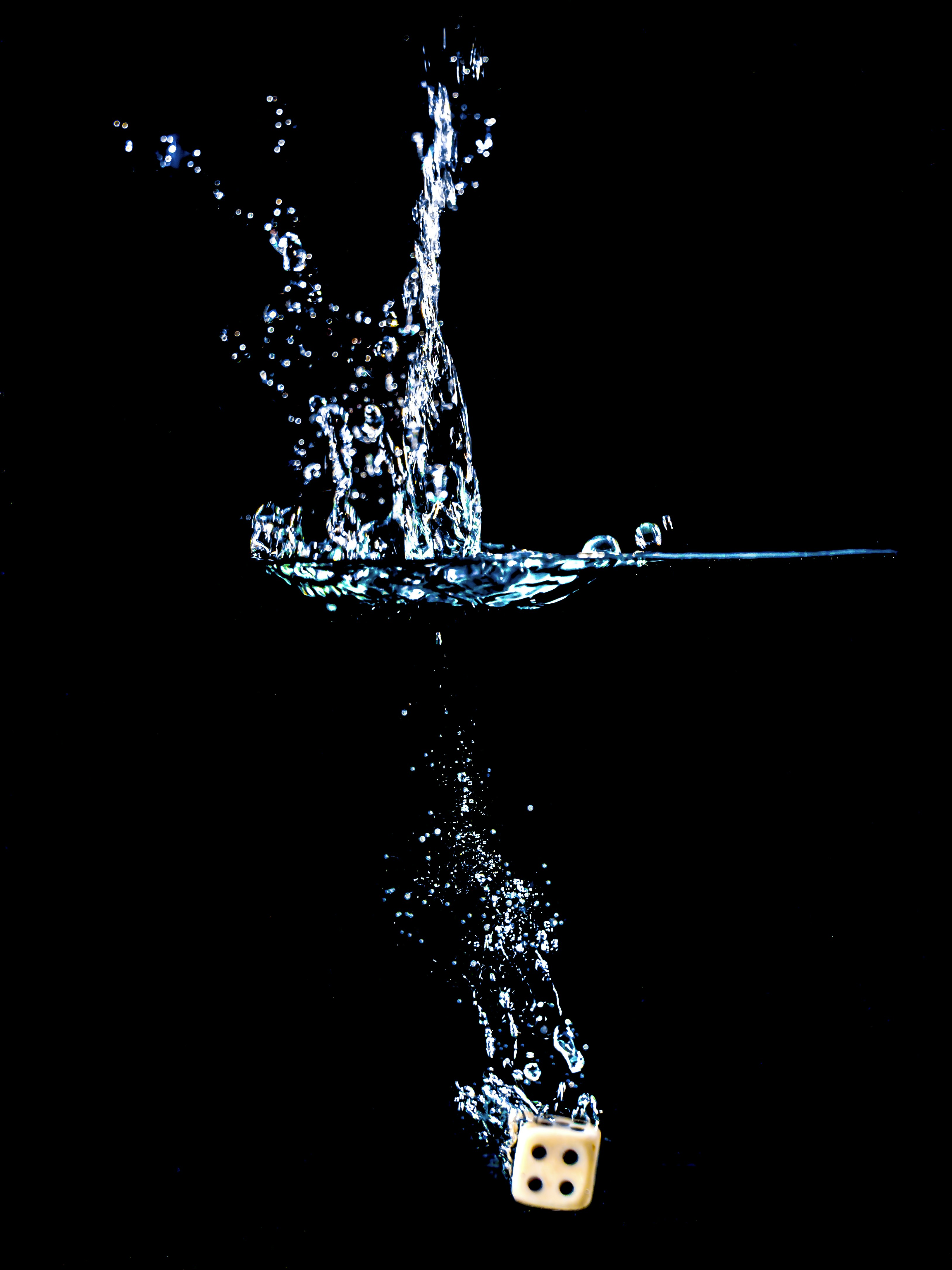 Dice plummet into water, creating a splash.