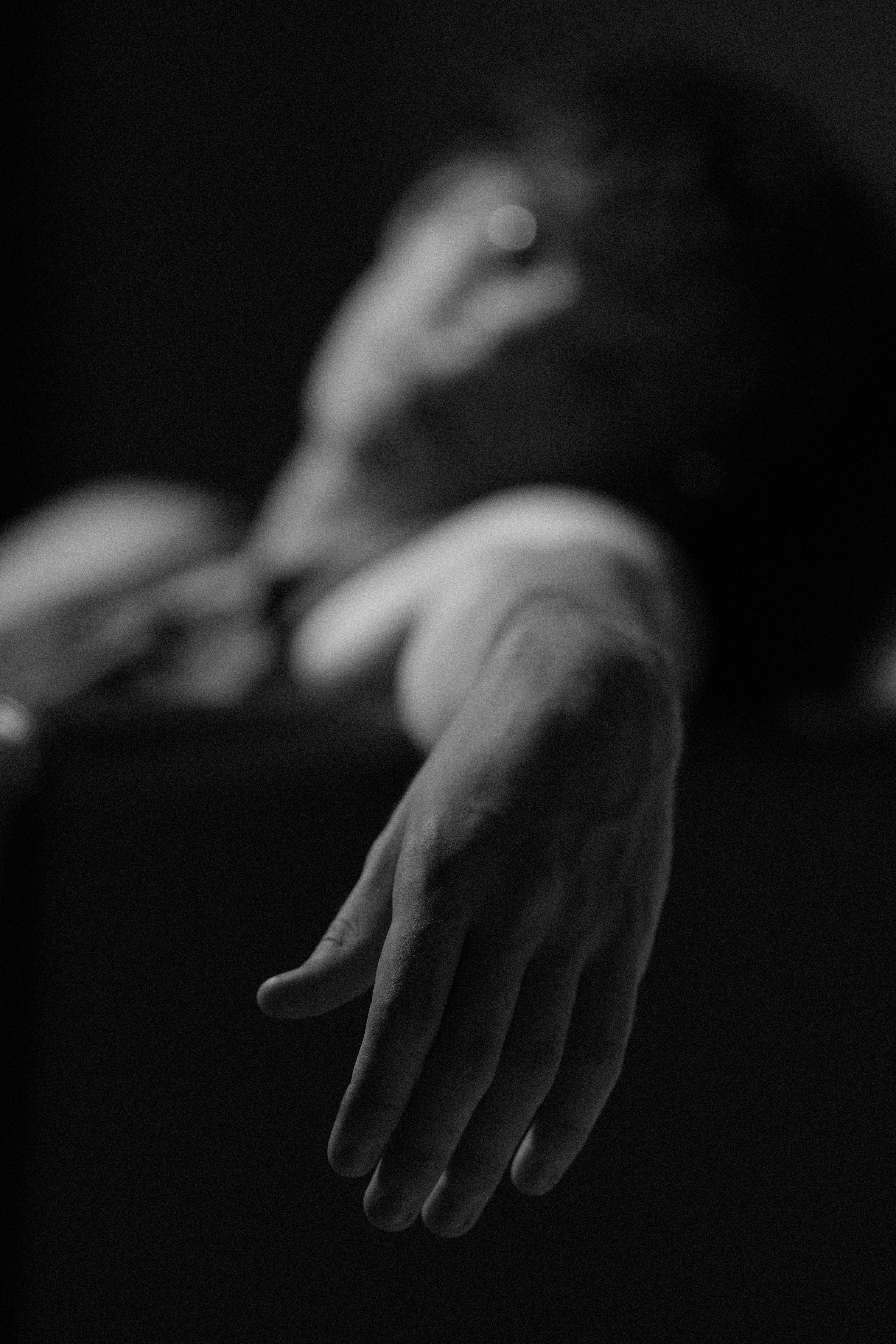 A hand is outstretched in a black and white photo.