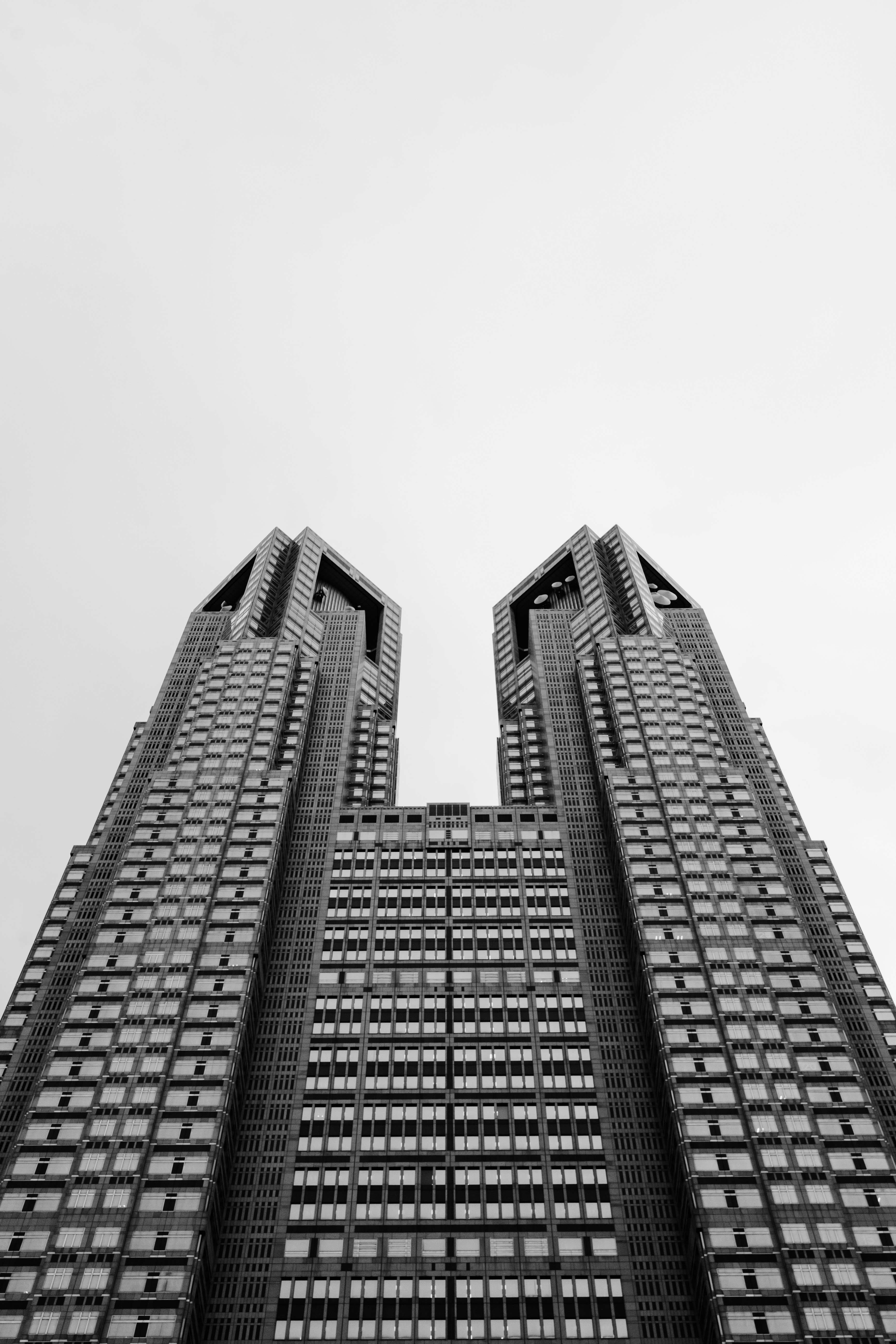 Tall skyscrapers stand in the sky in black and white.