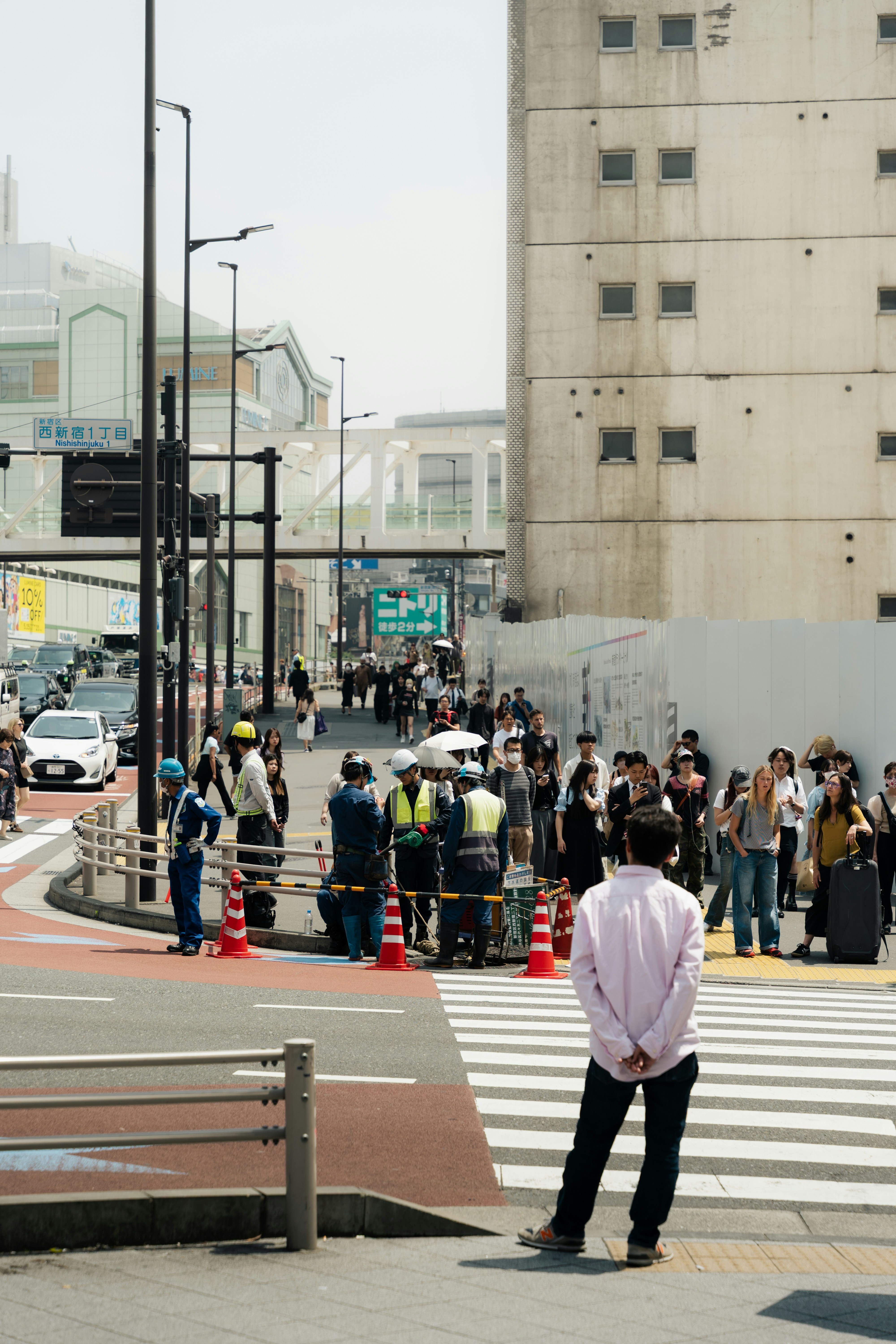 People stand on a busy street corner.