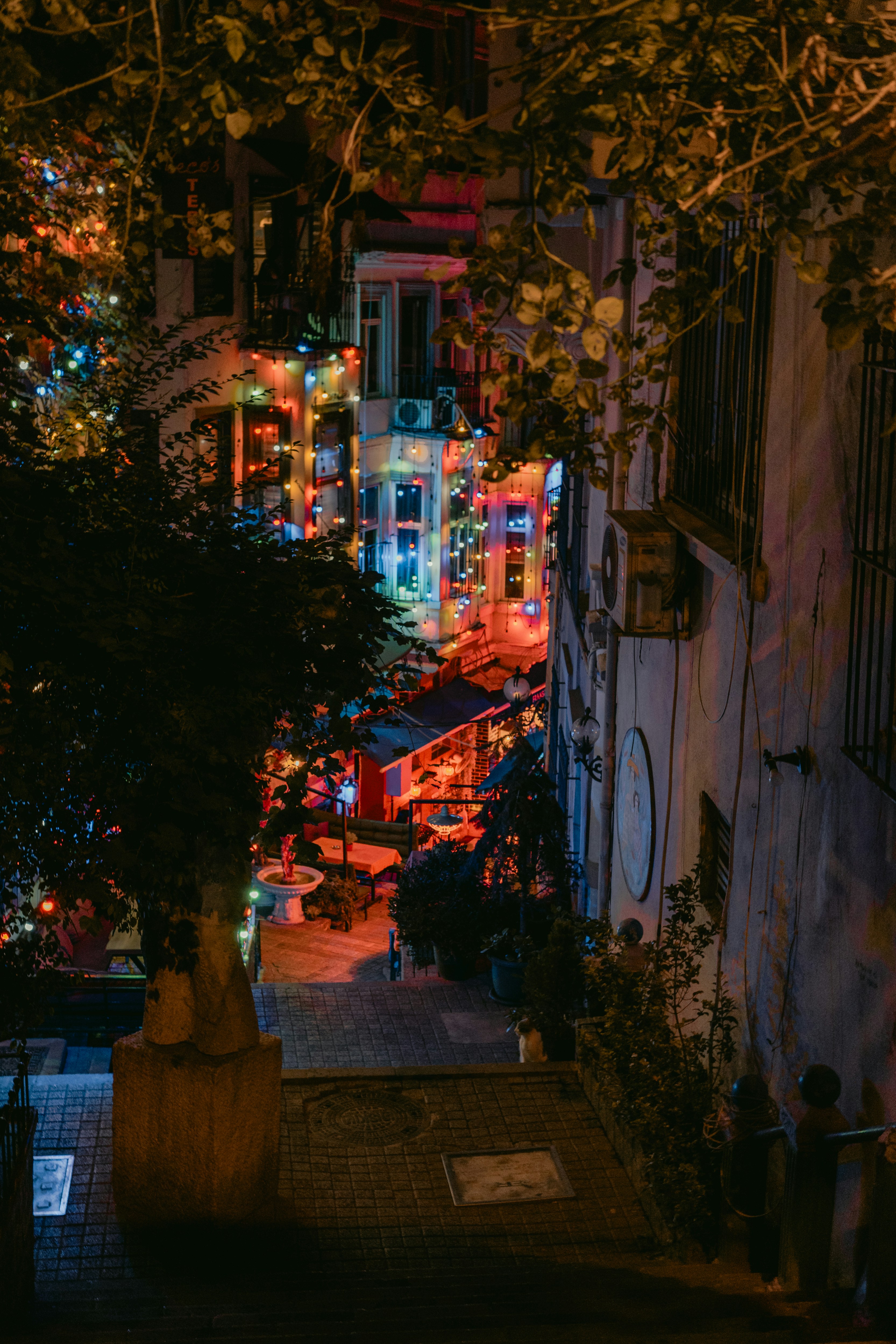 City alley illuminated with colorful lights at night.