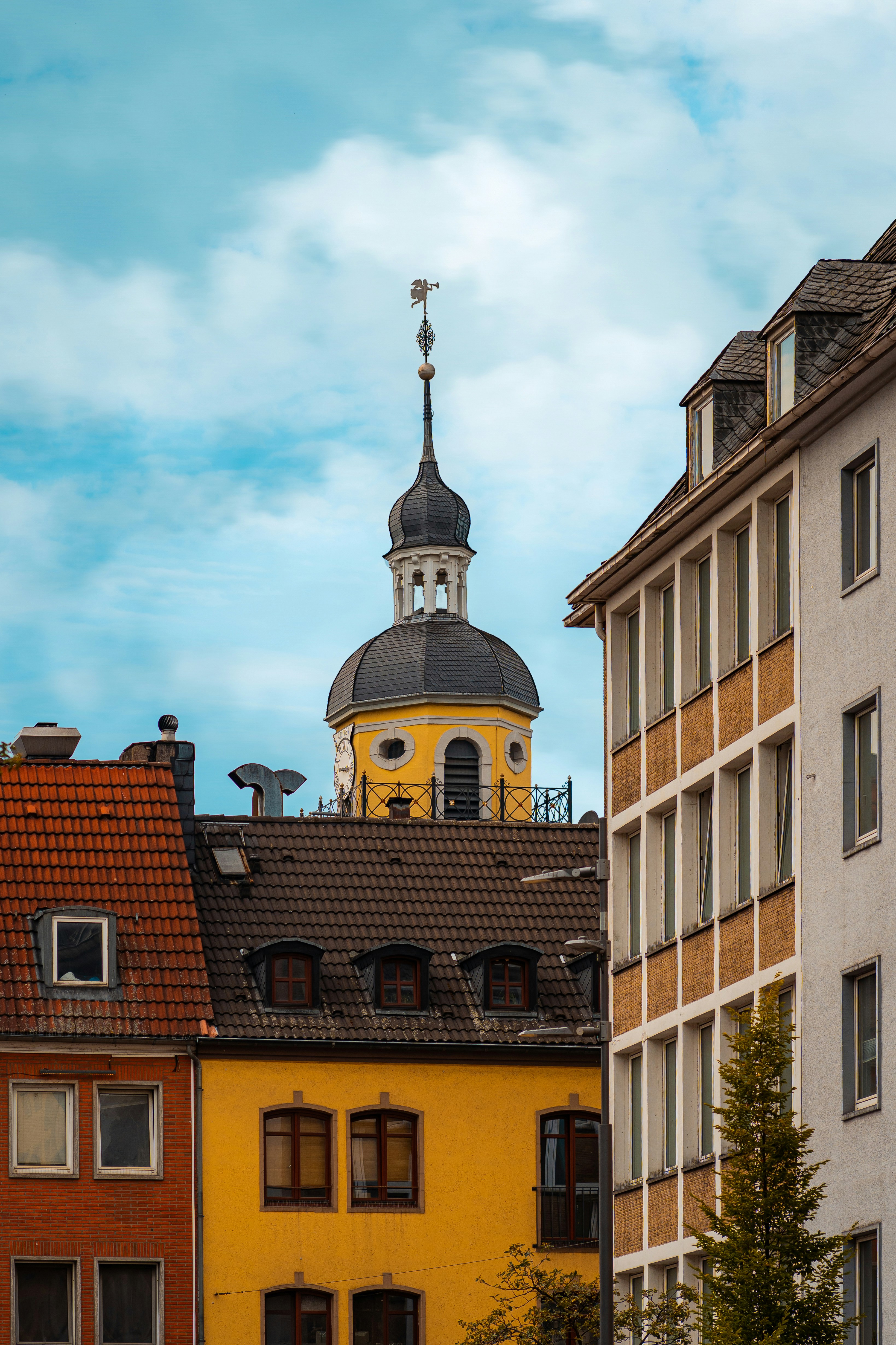 A church steeple rises above colorful buildings.