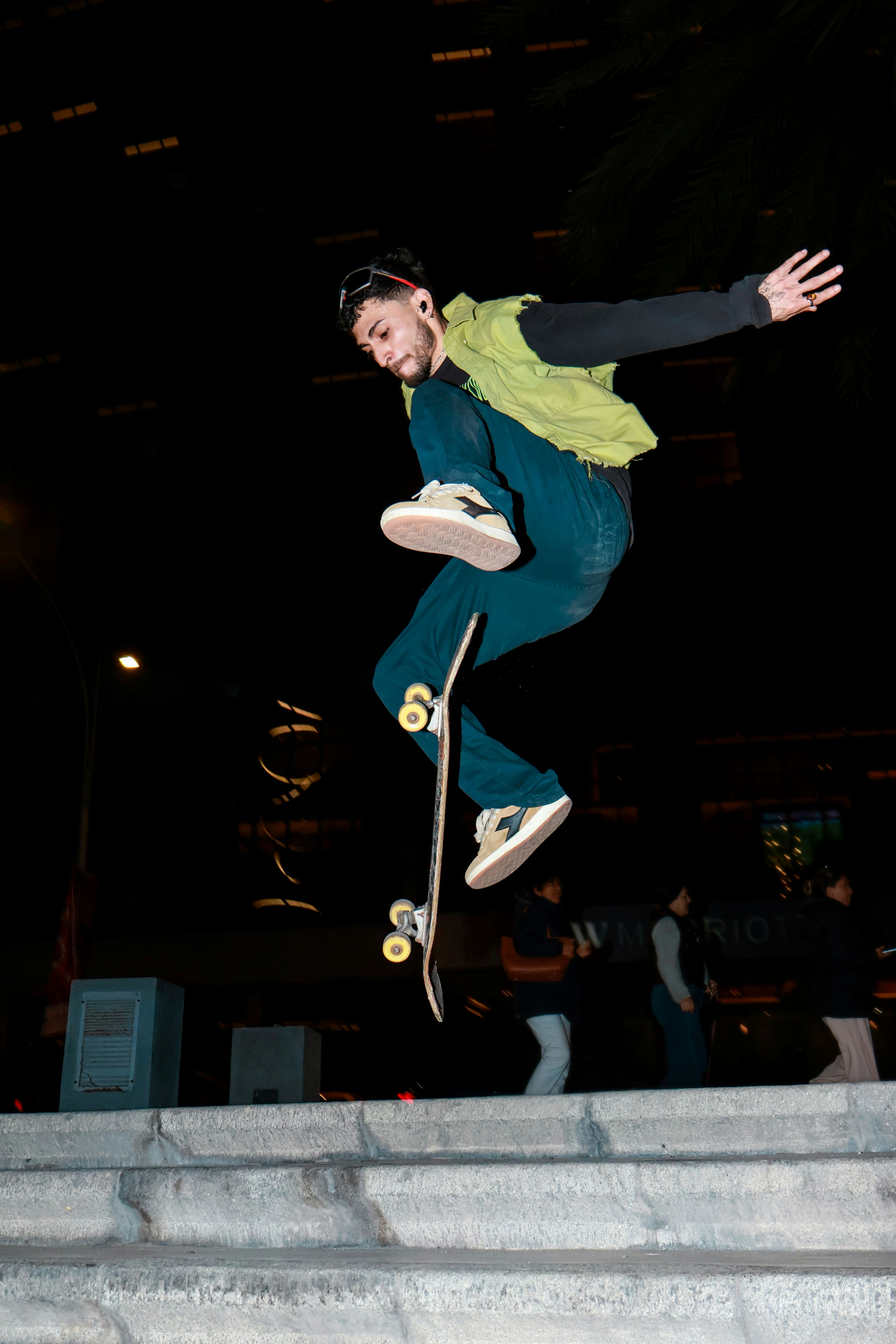 A skateboarder is doing a trick at night.