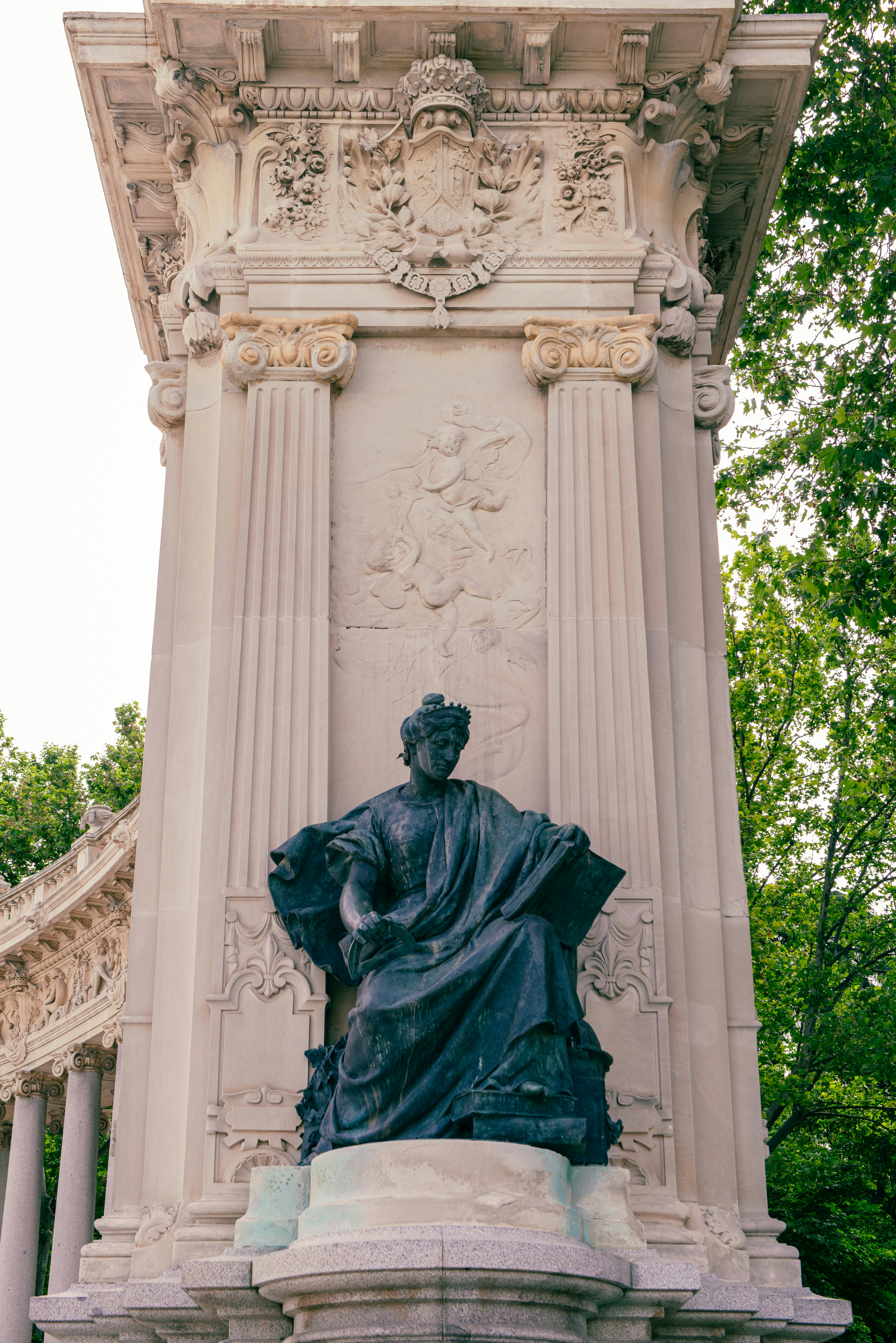 A statue sits before ornate architectural details.