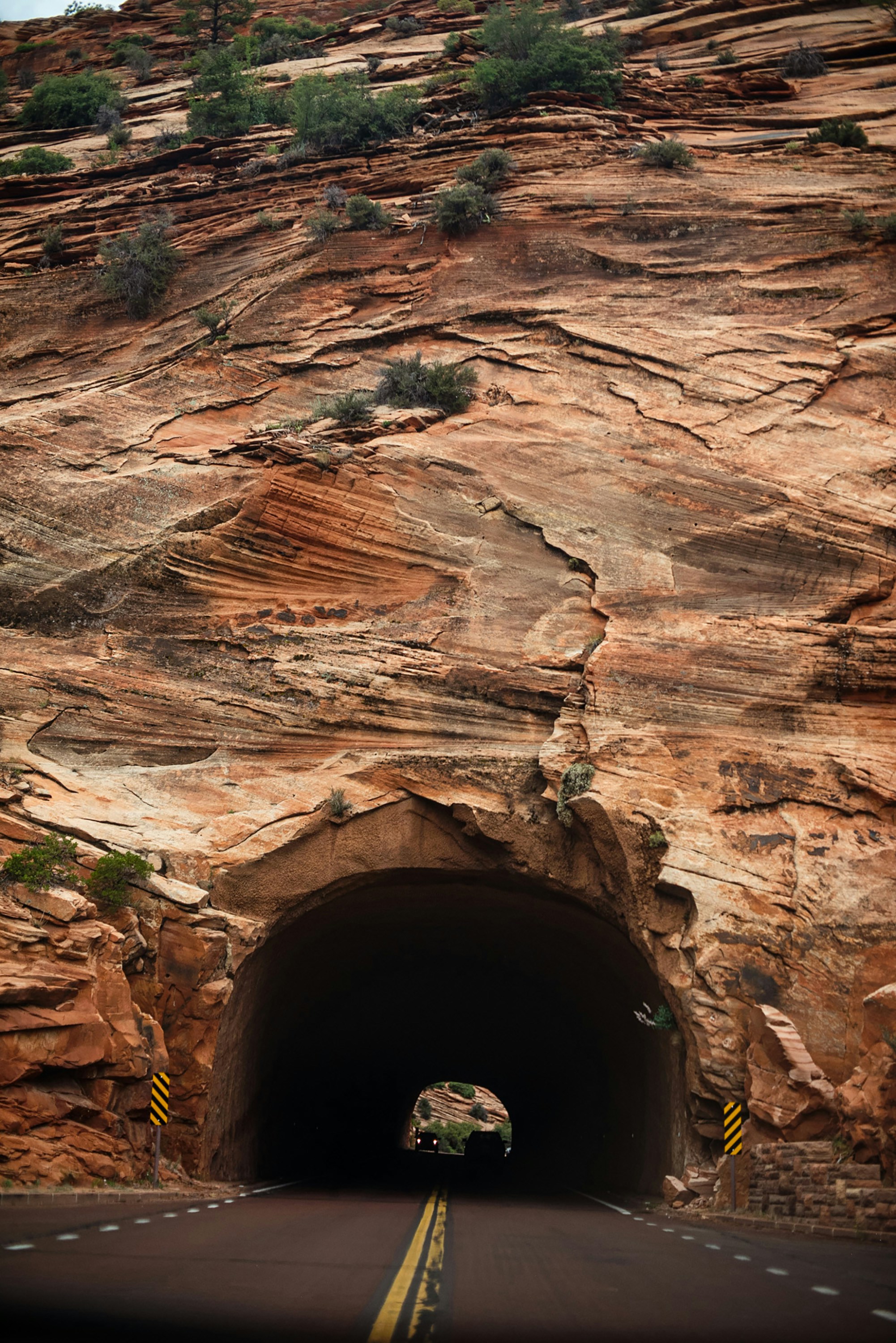 A road leads through a tunnel in a mountain.