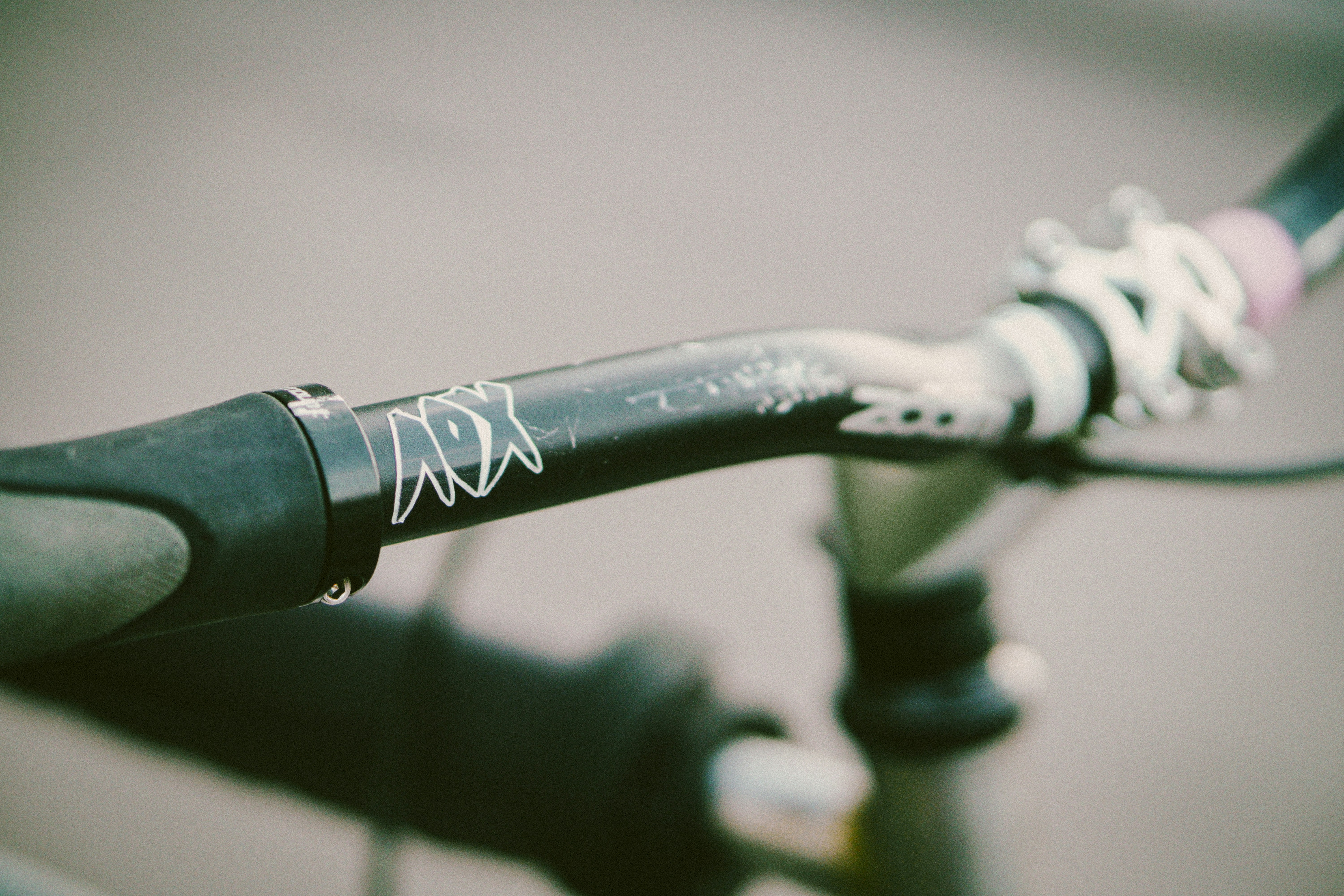 Close-up of a bicycle handlebar showcasing intricate details and a unique logo. The image highlights the essential gear of an avid cyclist.