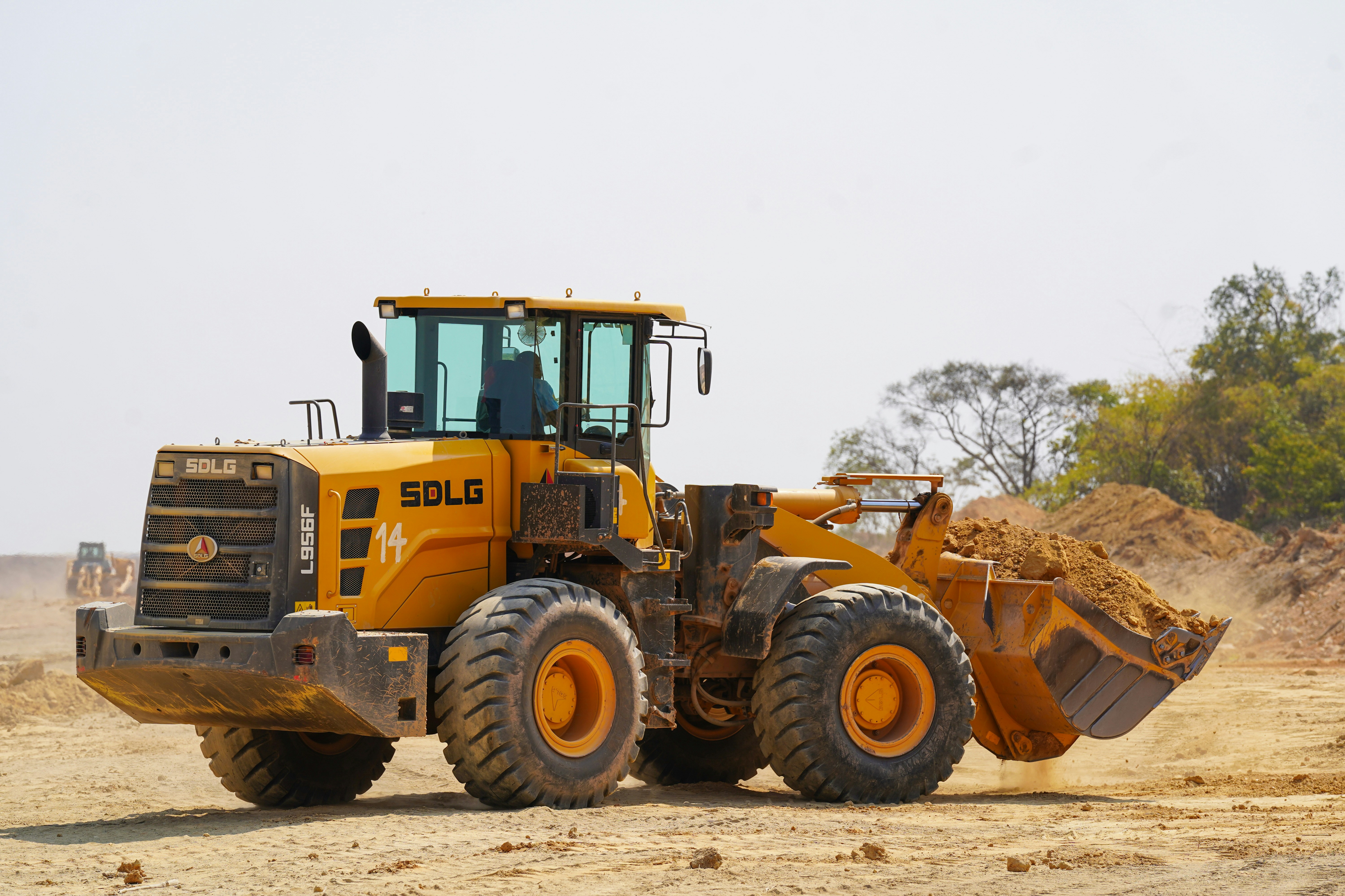 A yellow front loader working on a construction site. photo – Free ...