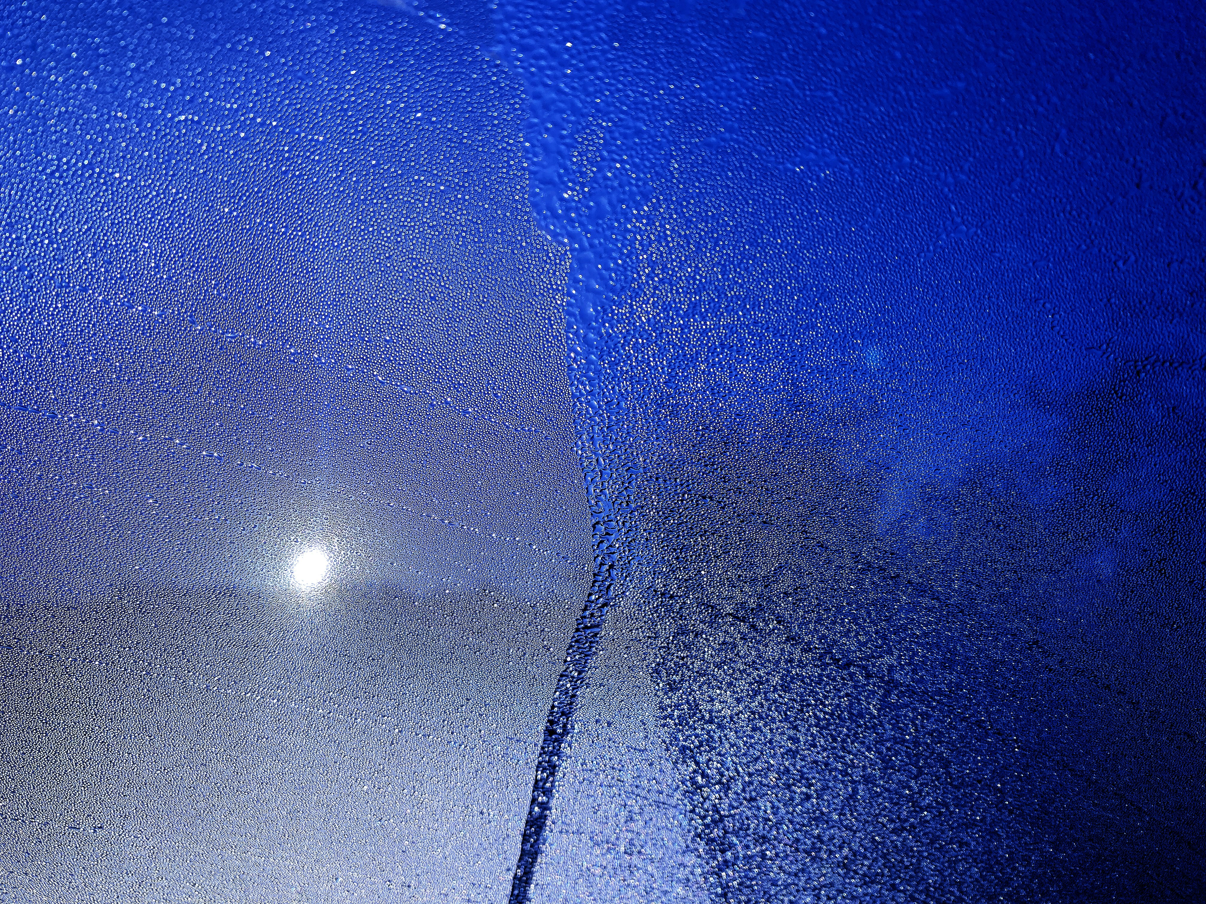 Blue Ice: Light Streaks Across a Frosted Window