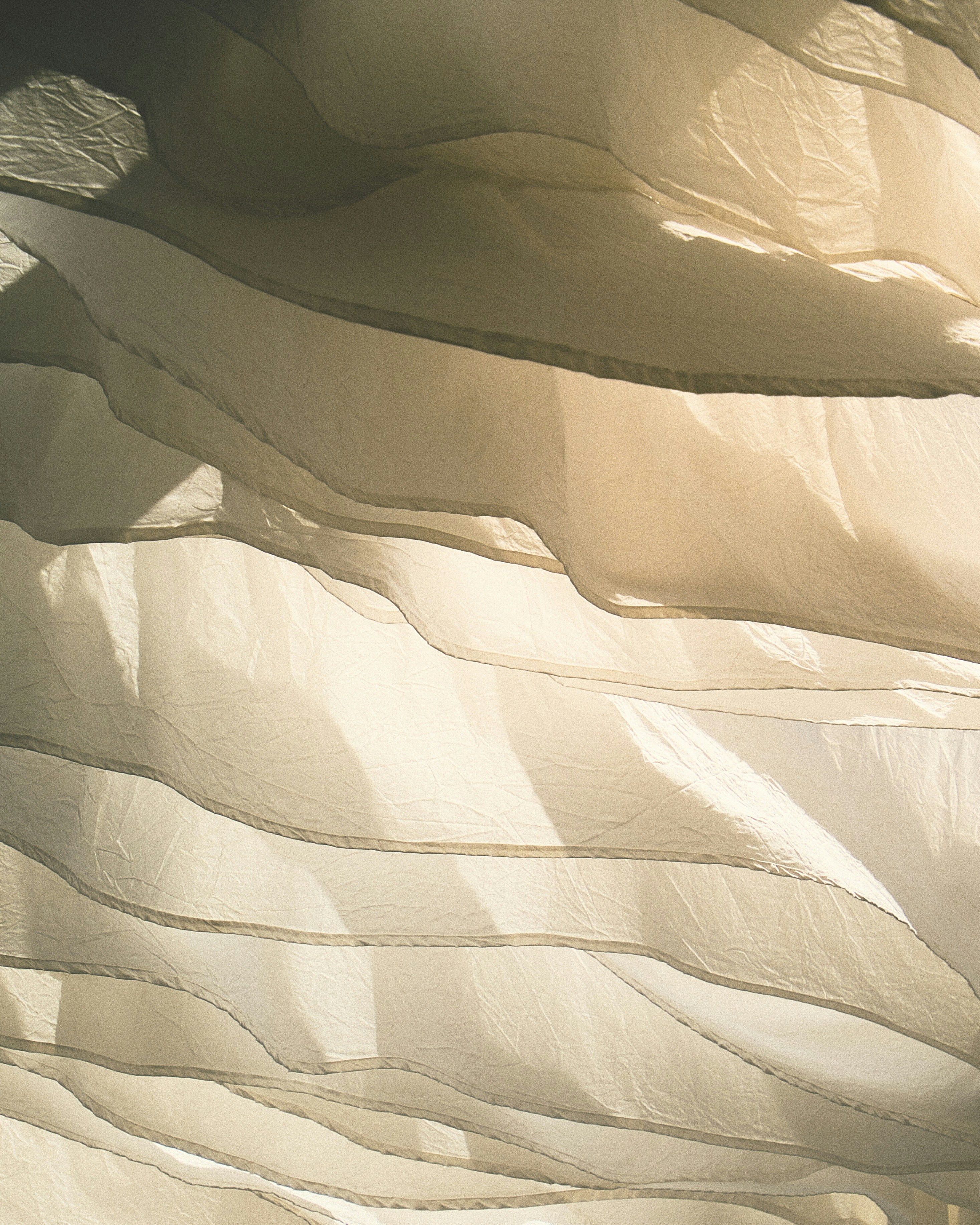abstract image of wavy cloth | Flowing, layered fabric illuminated by sunlight.