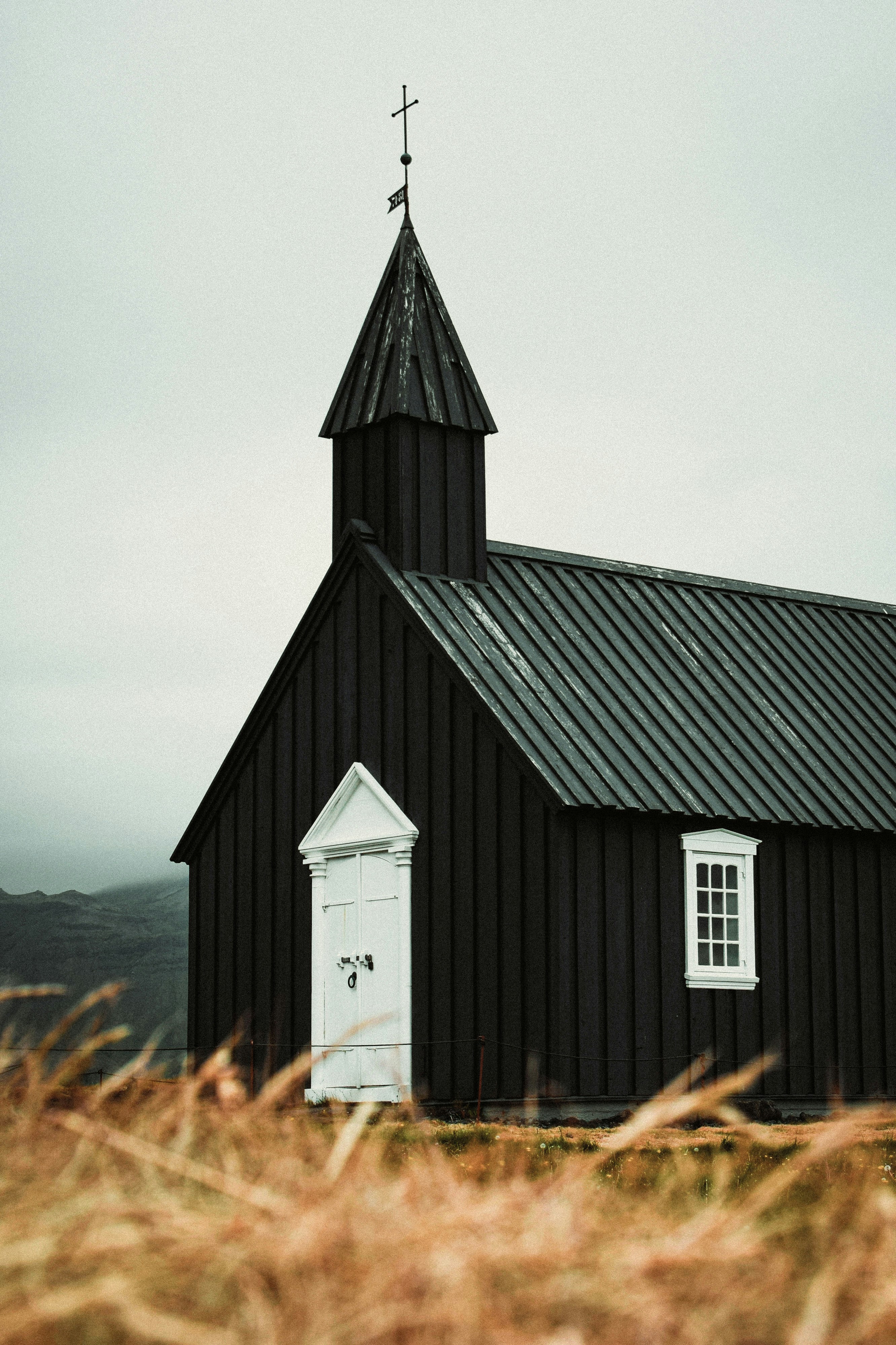 A black church stands against a gray sky.