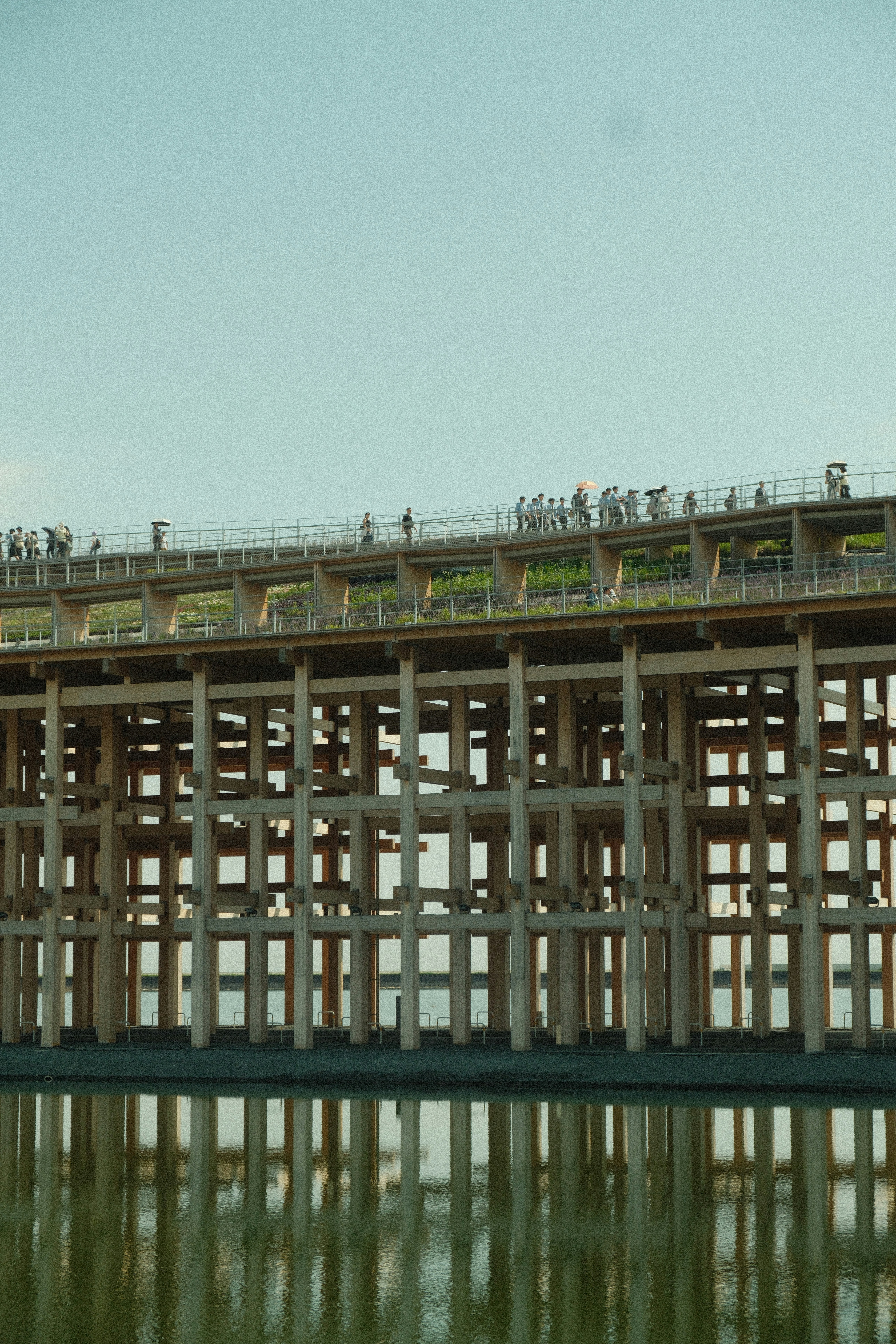 A wooden structure reflects in the calm water.