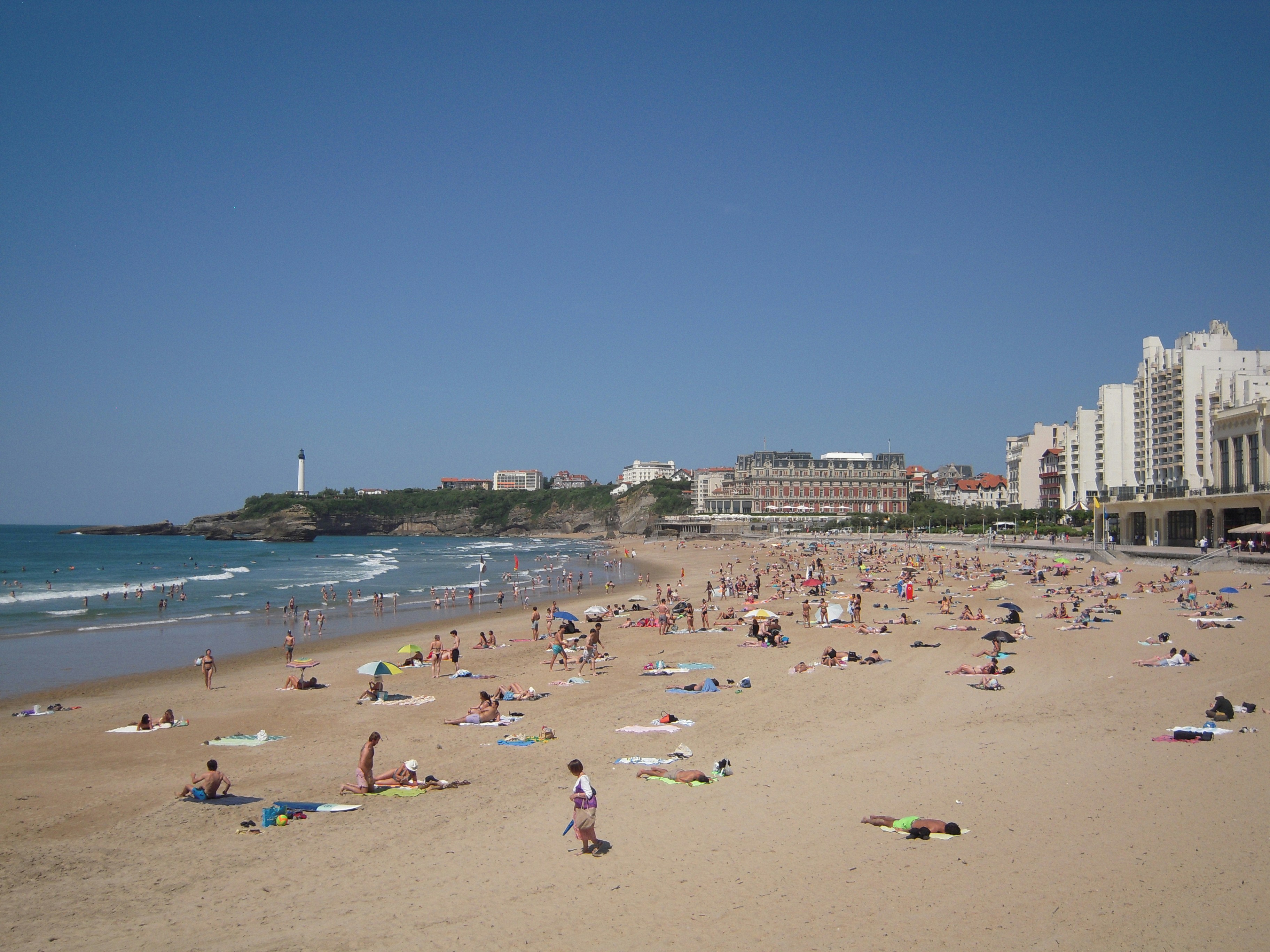 People are sunbathing on a crowded beach.