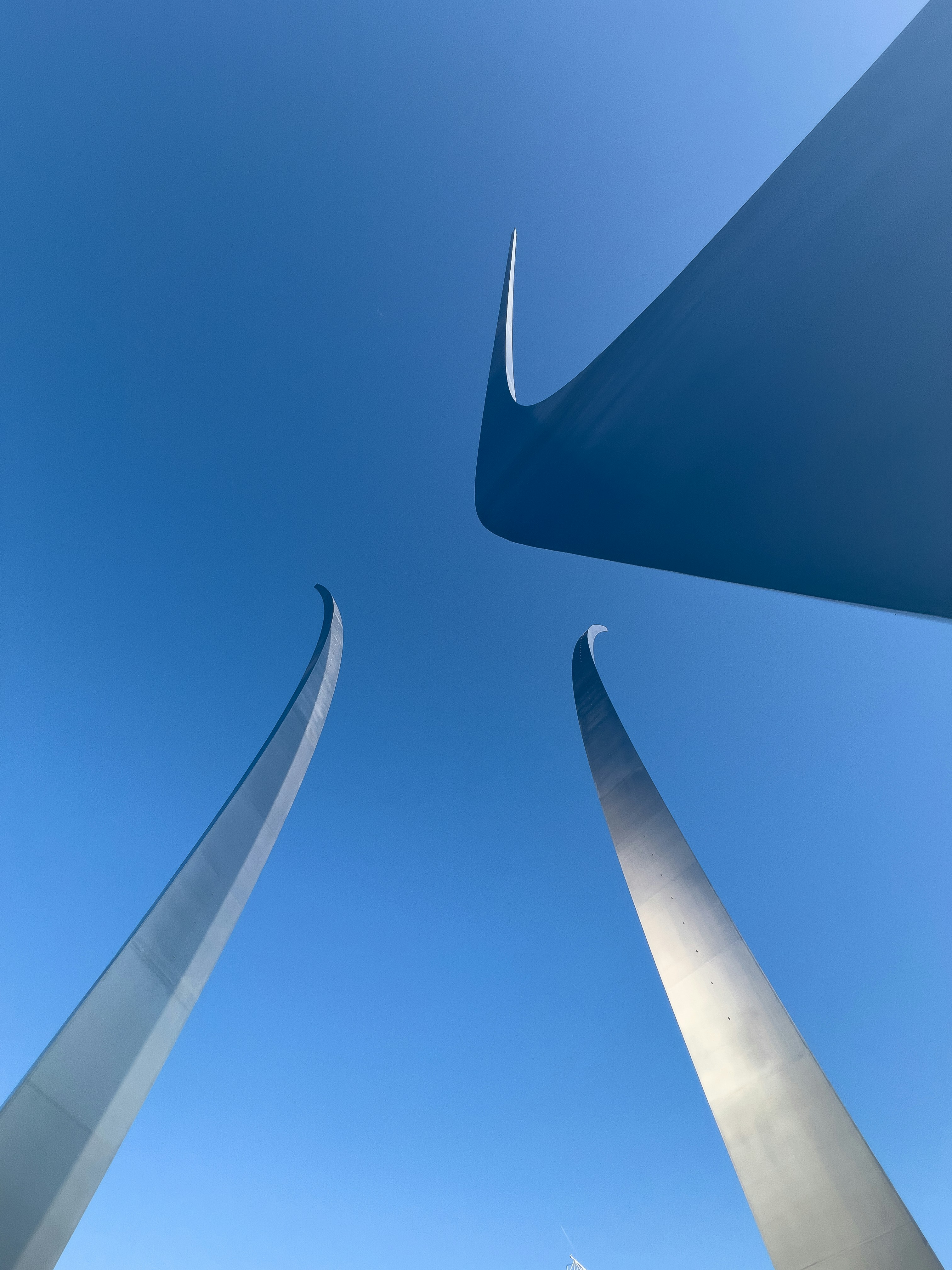 The air force memorial rises against a blue sky.