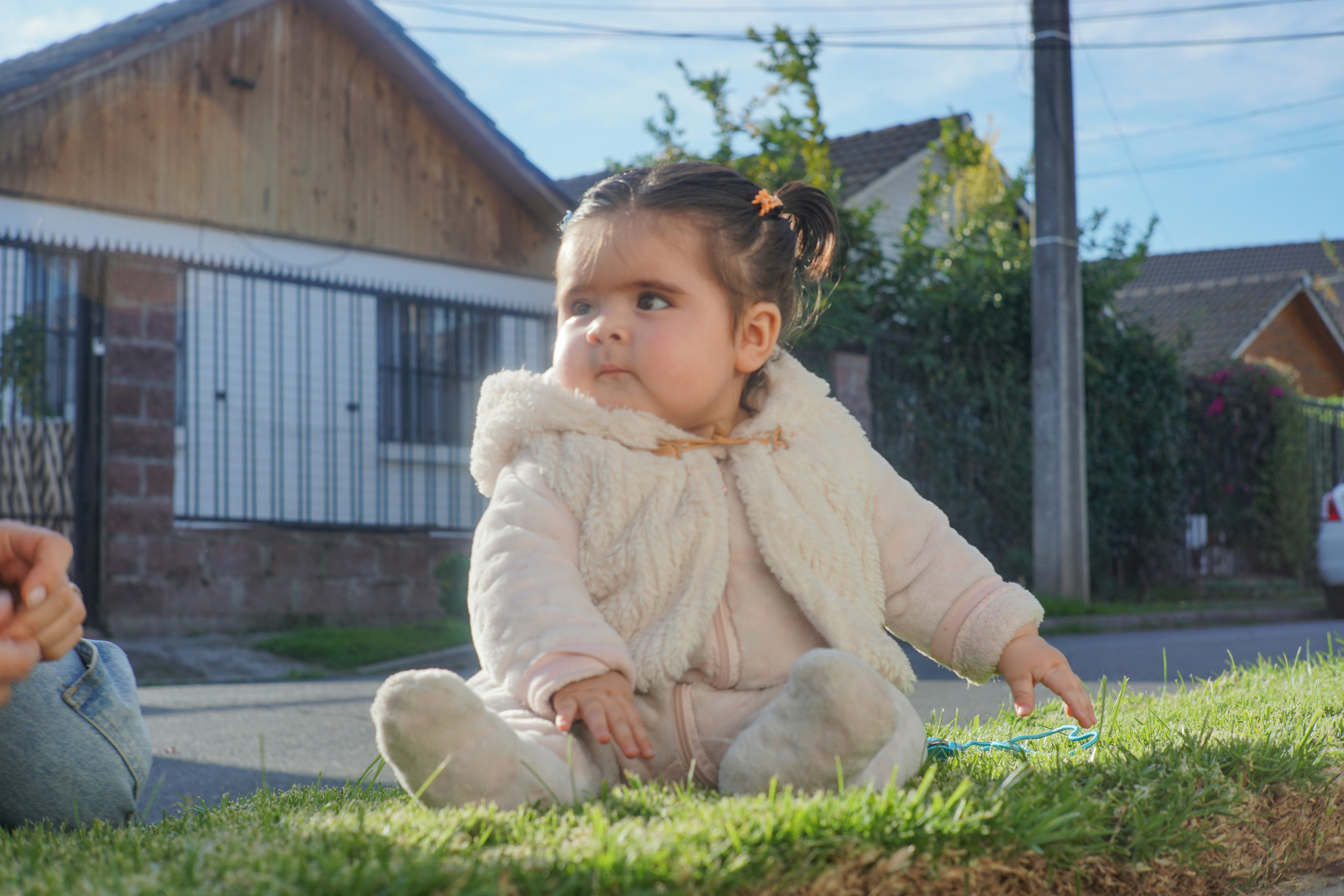 A cute baby sits in the sun.