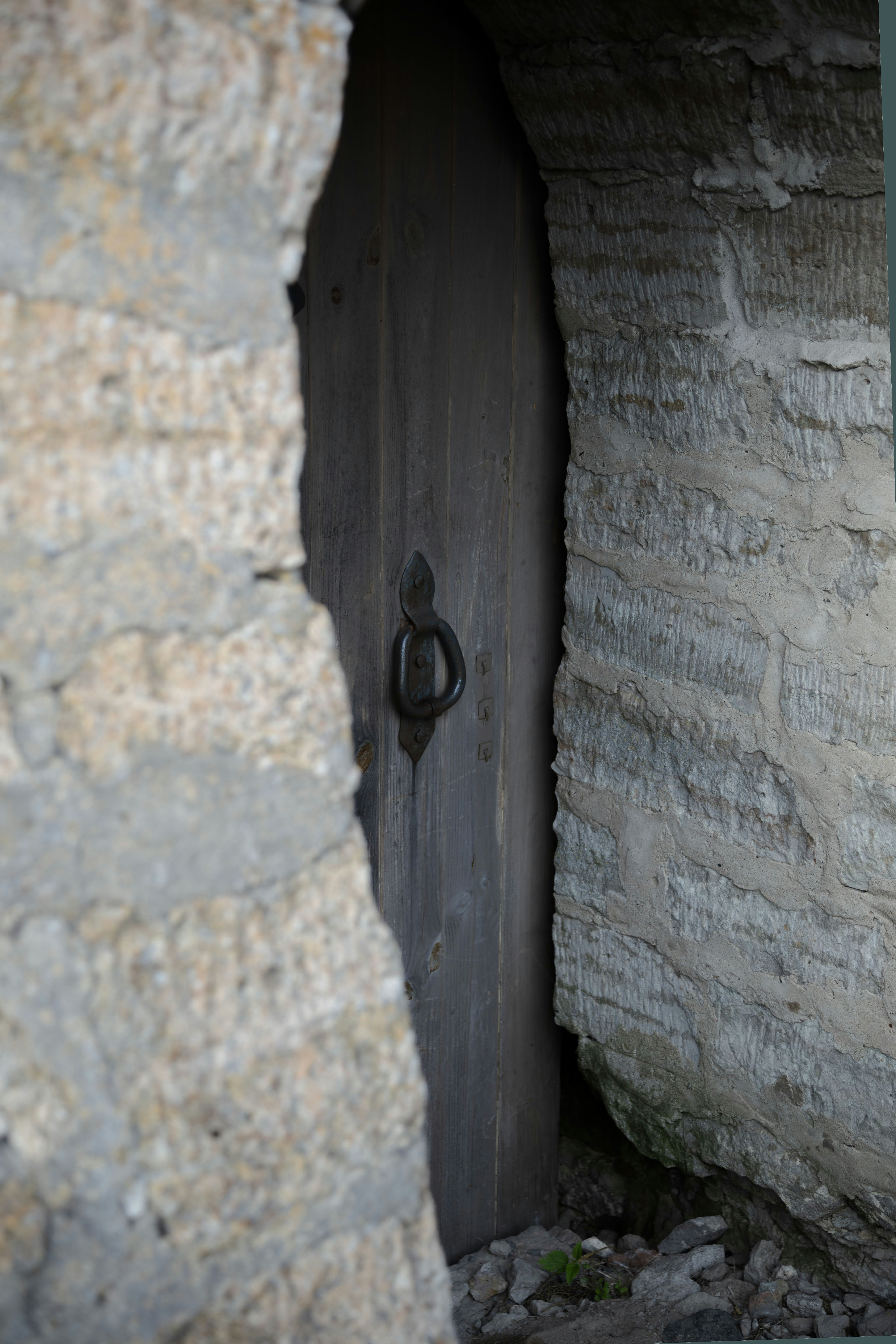 Old Ladoga, Russia | An old wooden door is framed by stone walls.