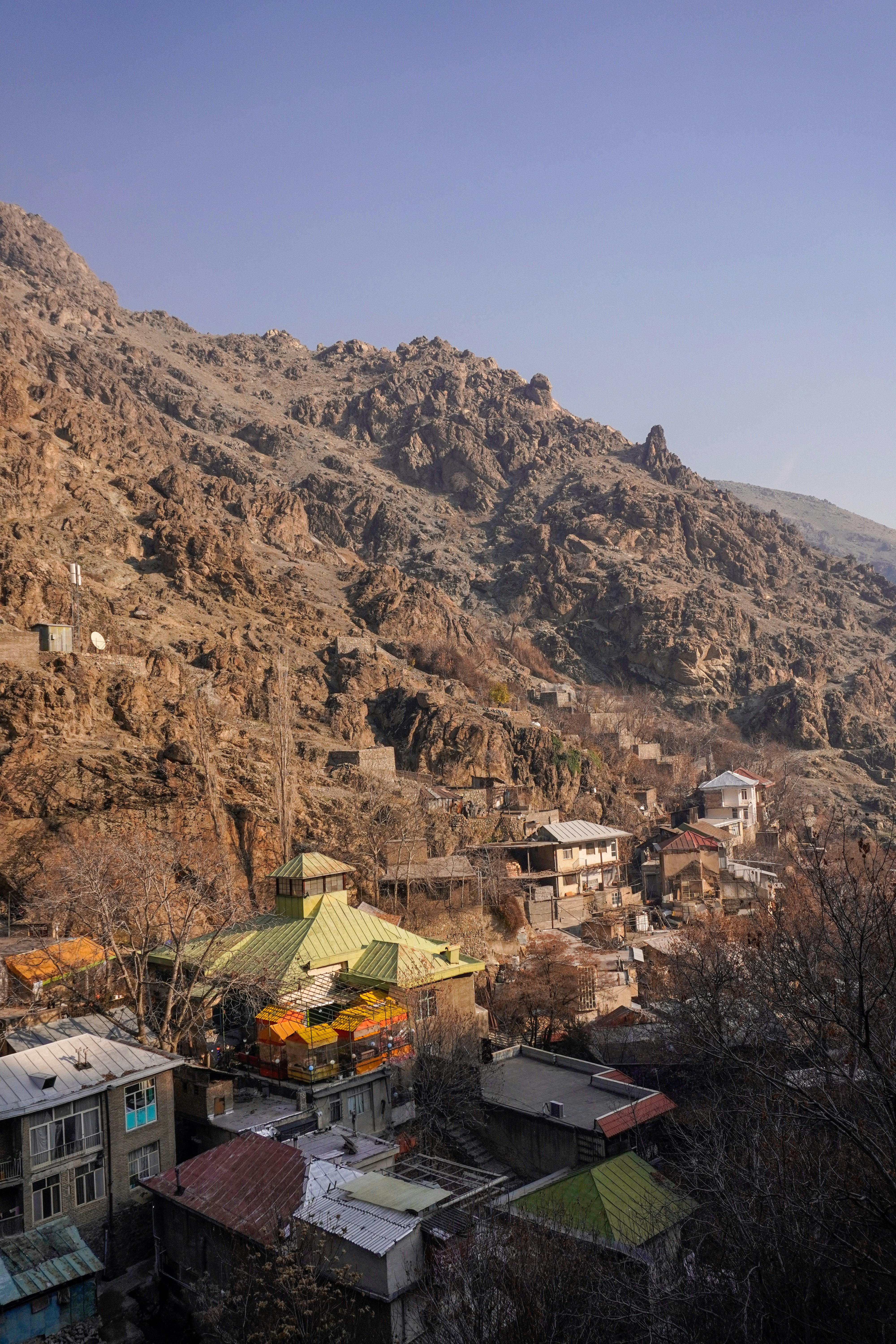 Houses nestled against a rugged mountain landscape.