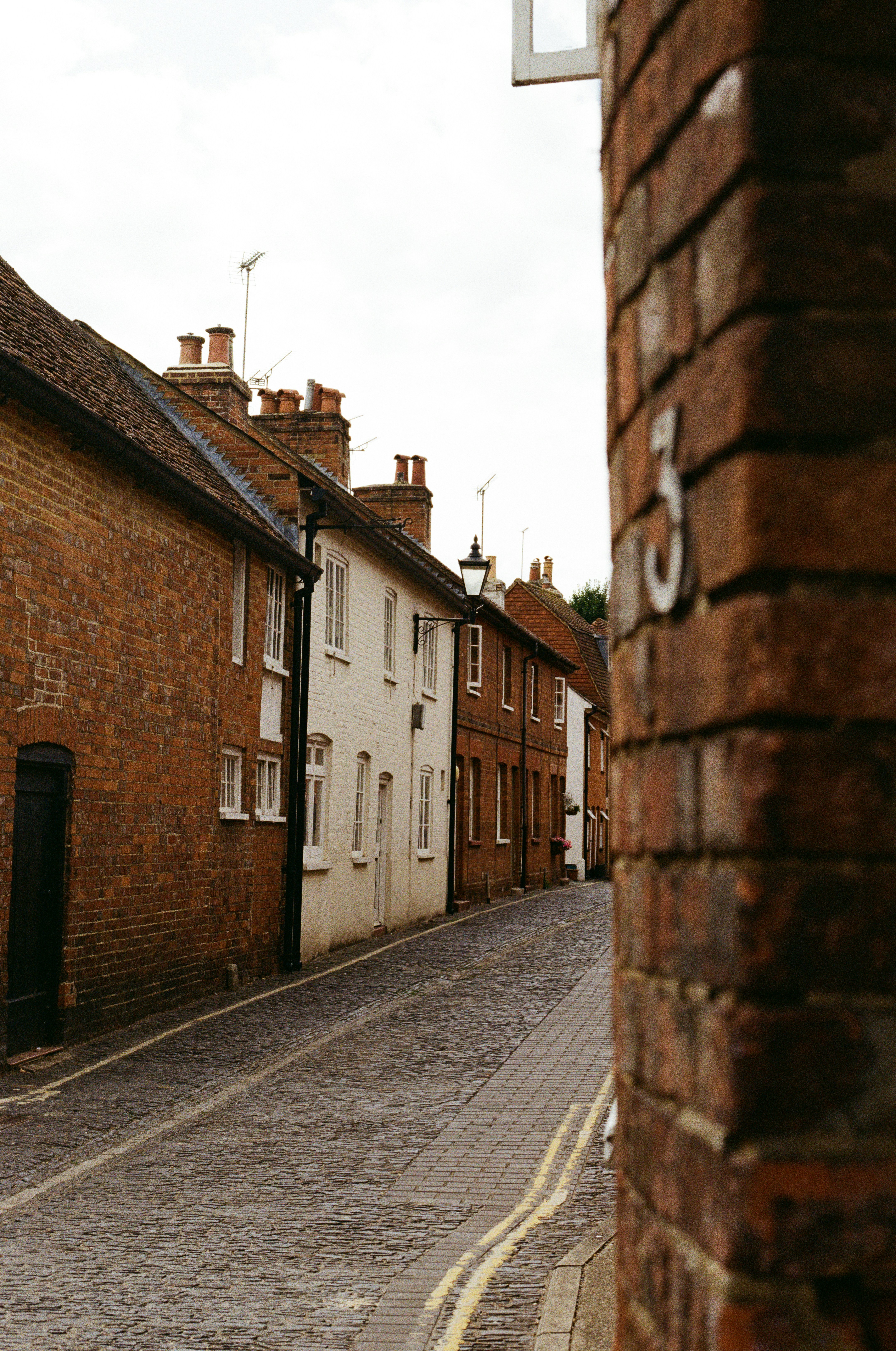 A cobblestone street lined with brick buildings.