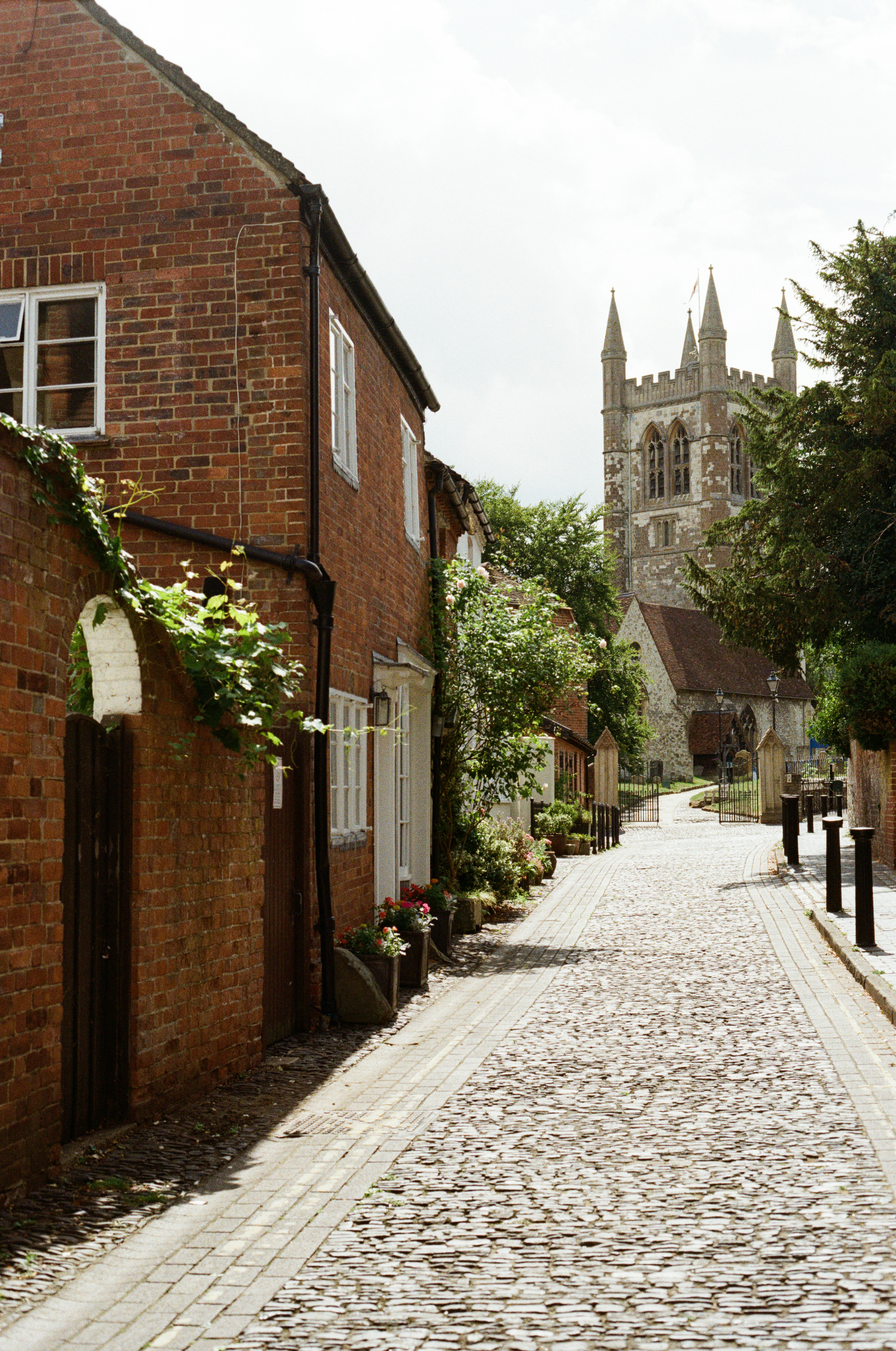 A quaint european street leads to a church.