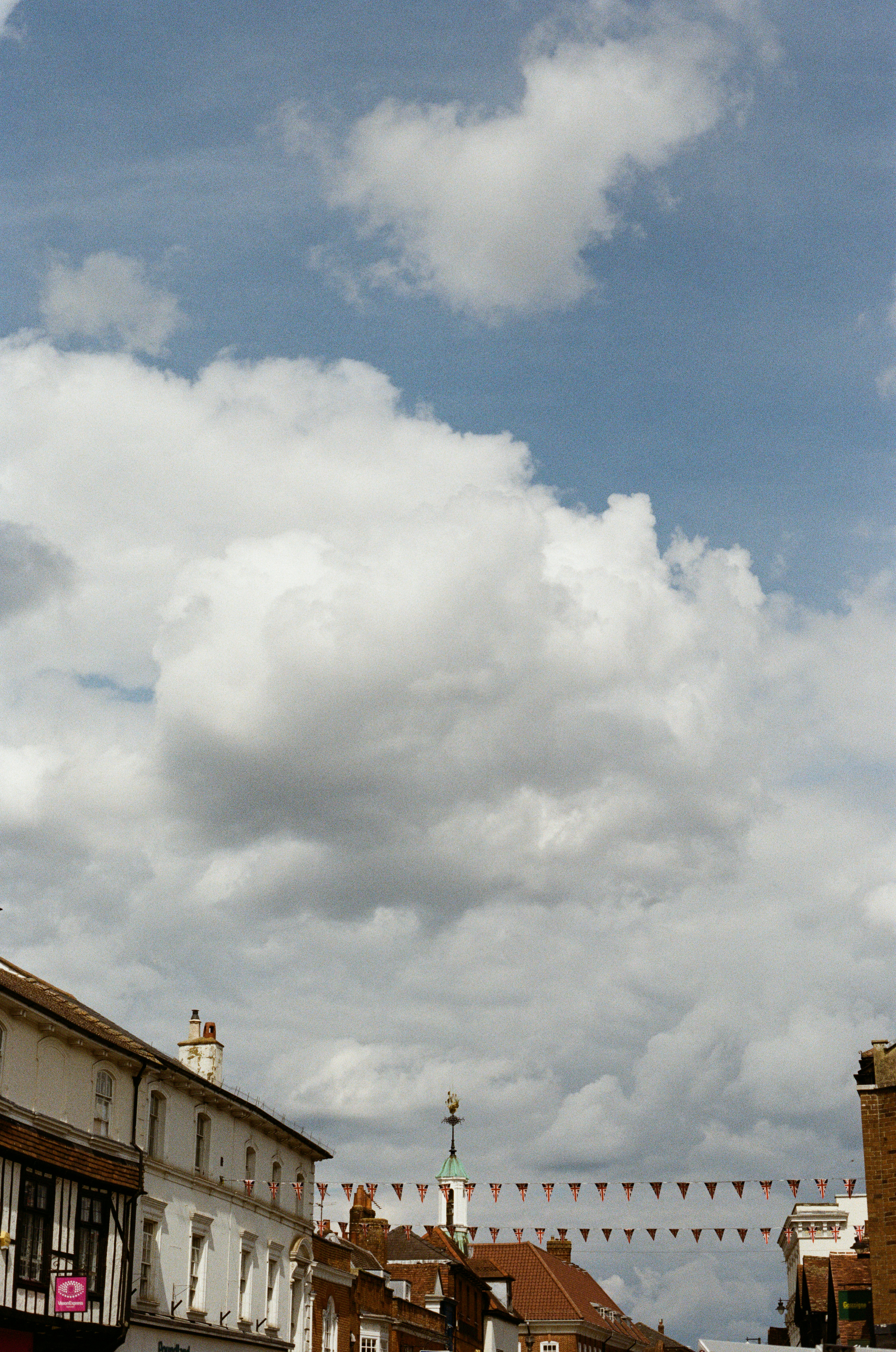 Clouds drift over a charming town on a sunny day.