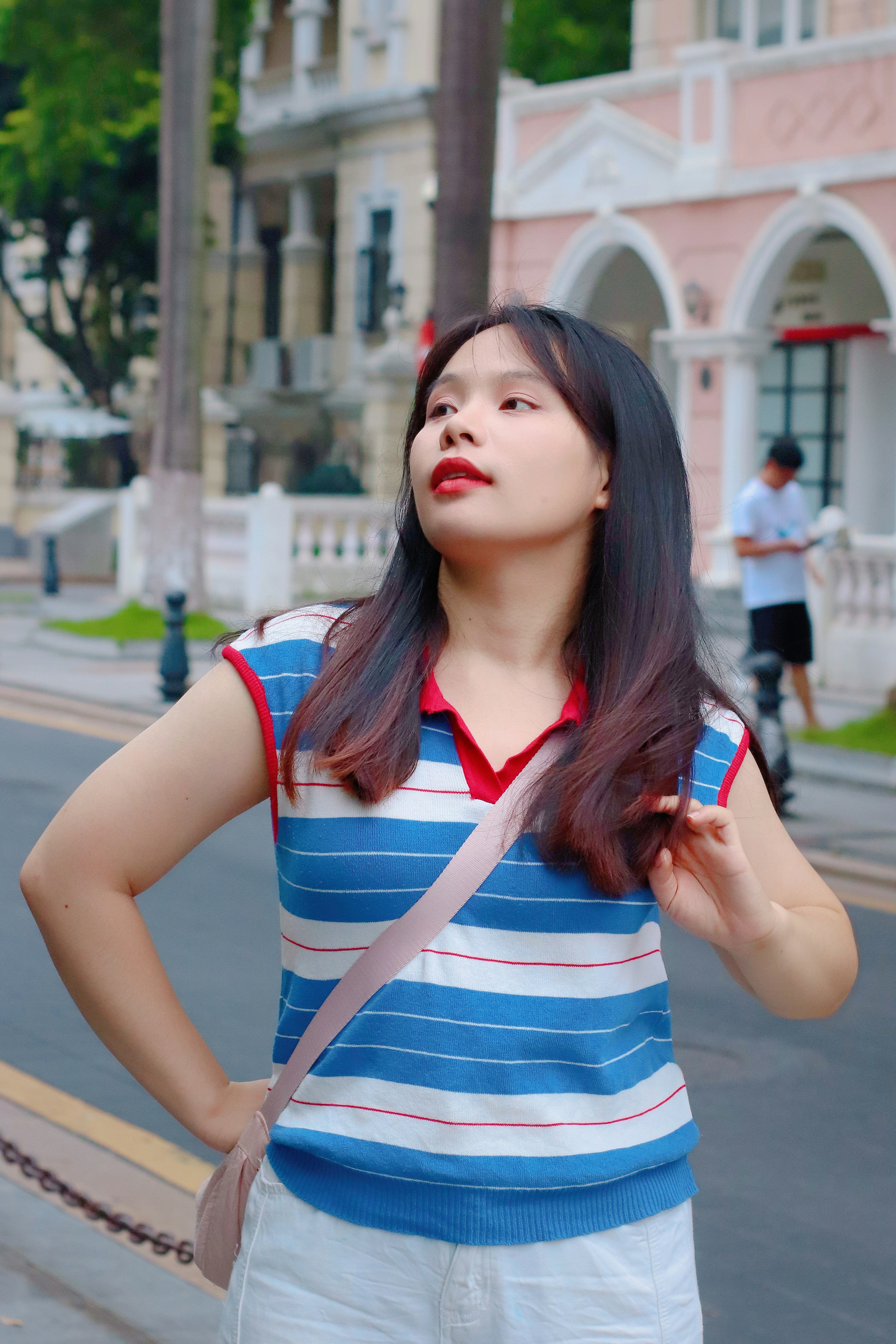 A woman poses on a city street.