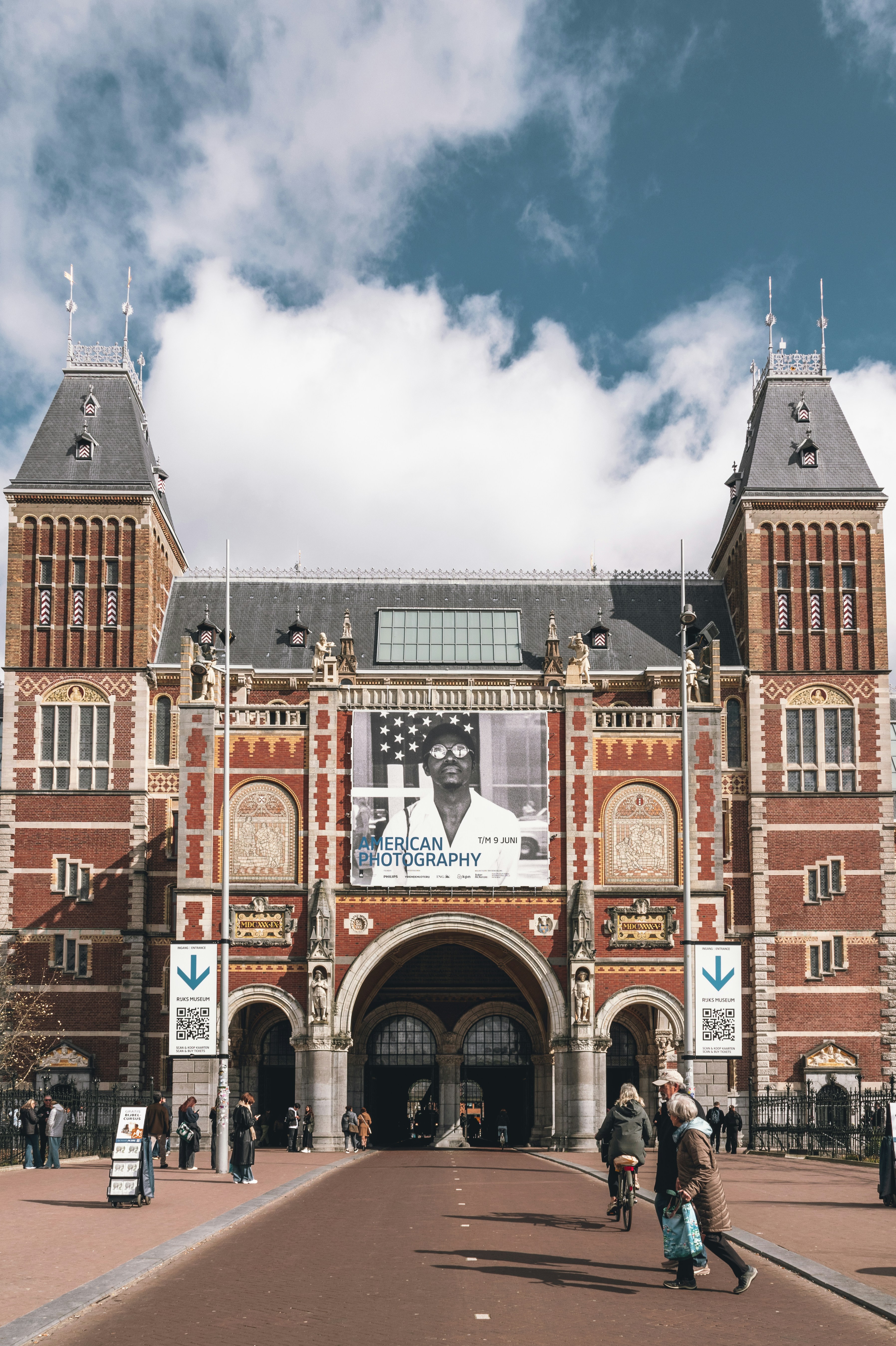 Frontal shot of the amazing Rjiskmuseum (National Art Museum) in Amsterdam | The rijksmuseum stands tall under a blue sky.