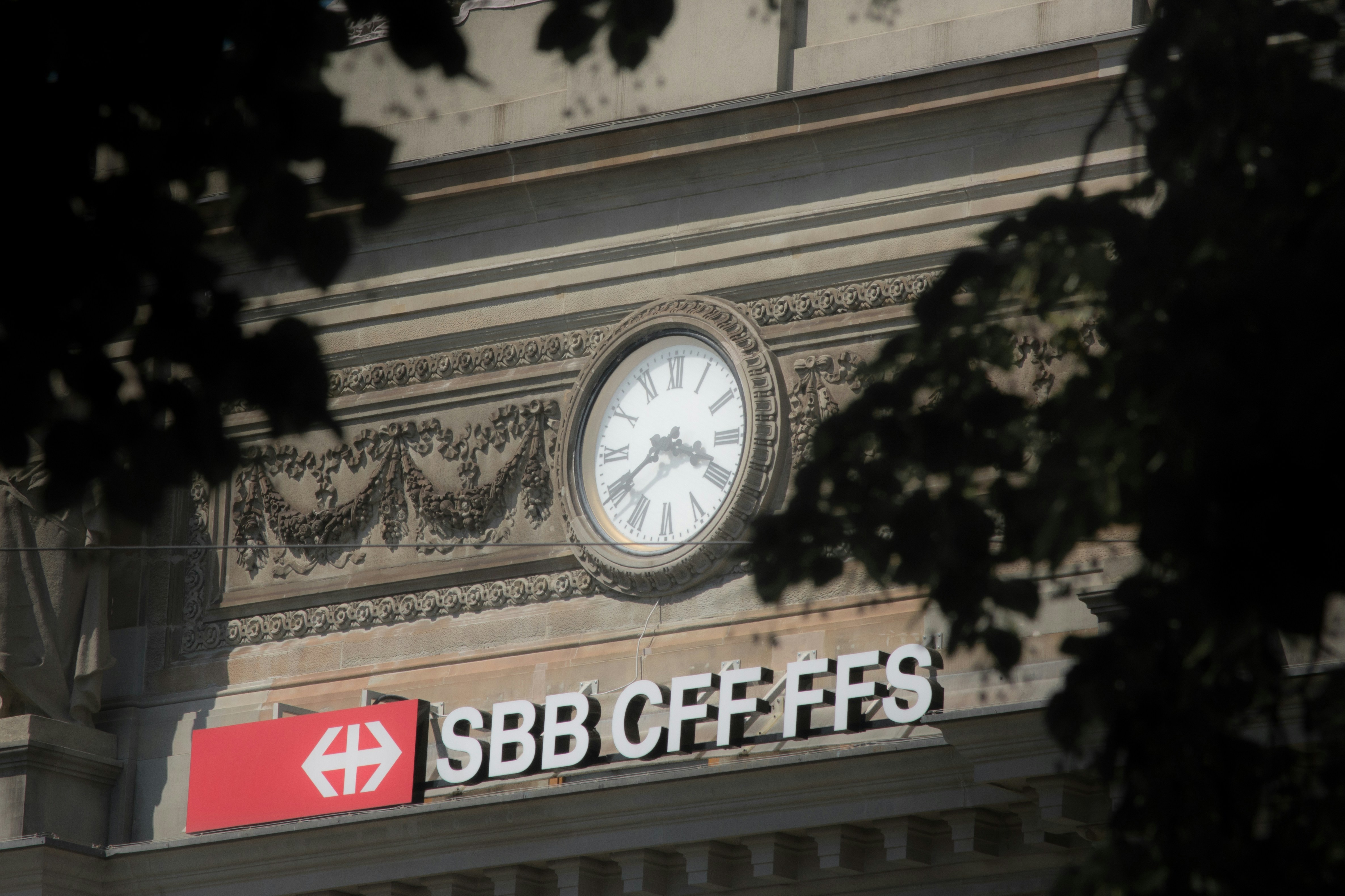 A building with a clock and sbb cff ffs sign. photo – Free Woman Image ...