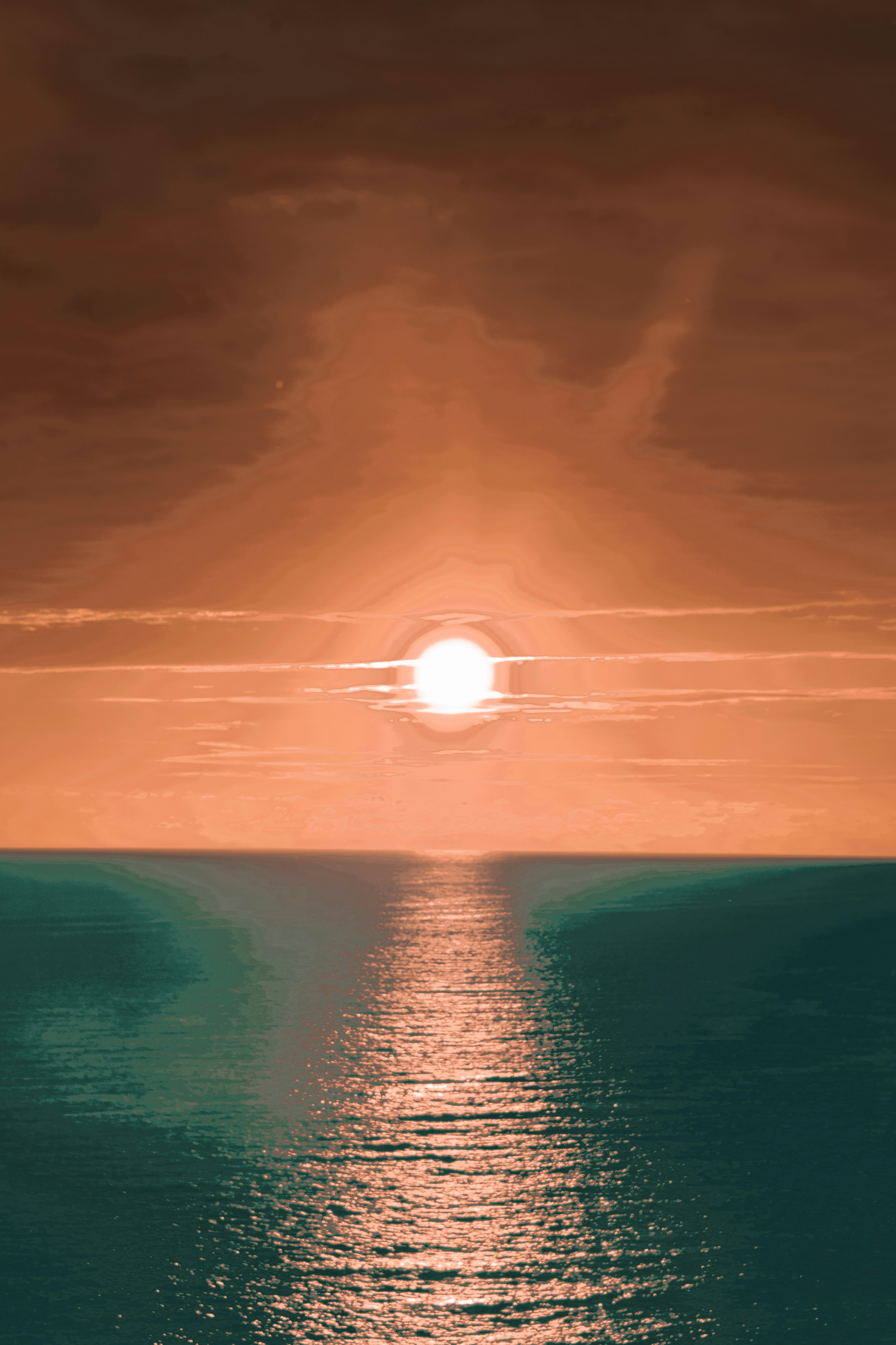 Sunset over the ocean reflecting the bright sun.