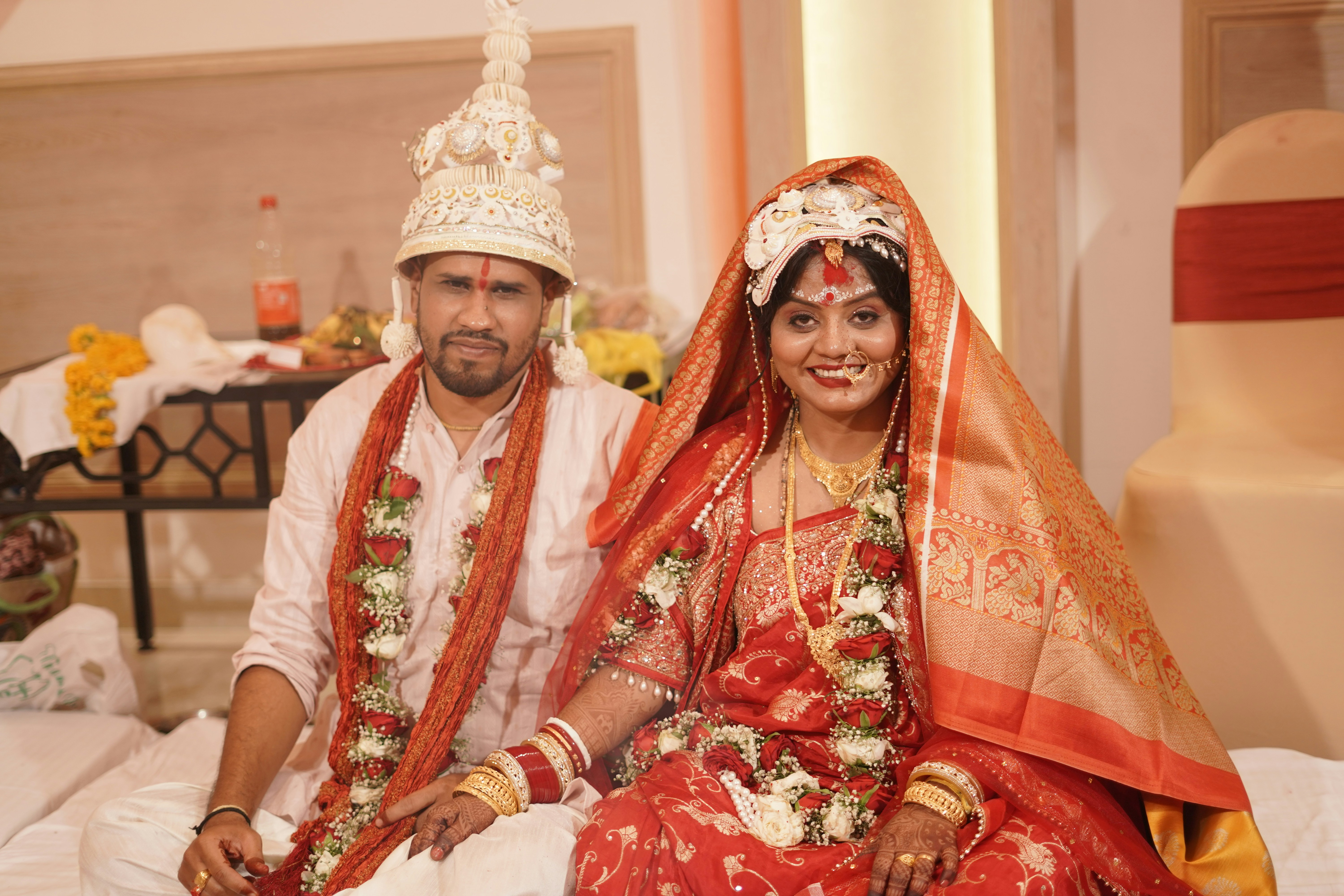 Bengali Wedding Rituals | A couple smiles during a wedding ceremony.