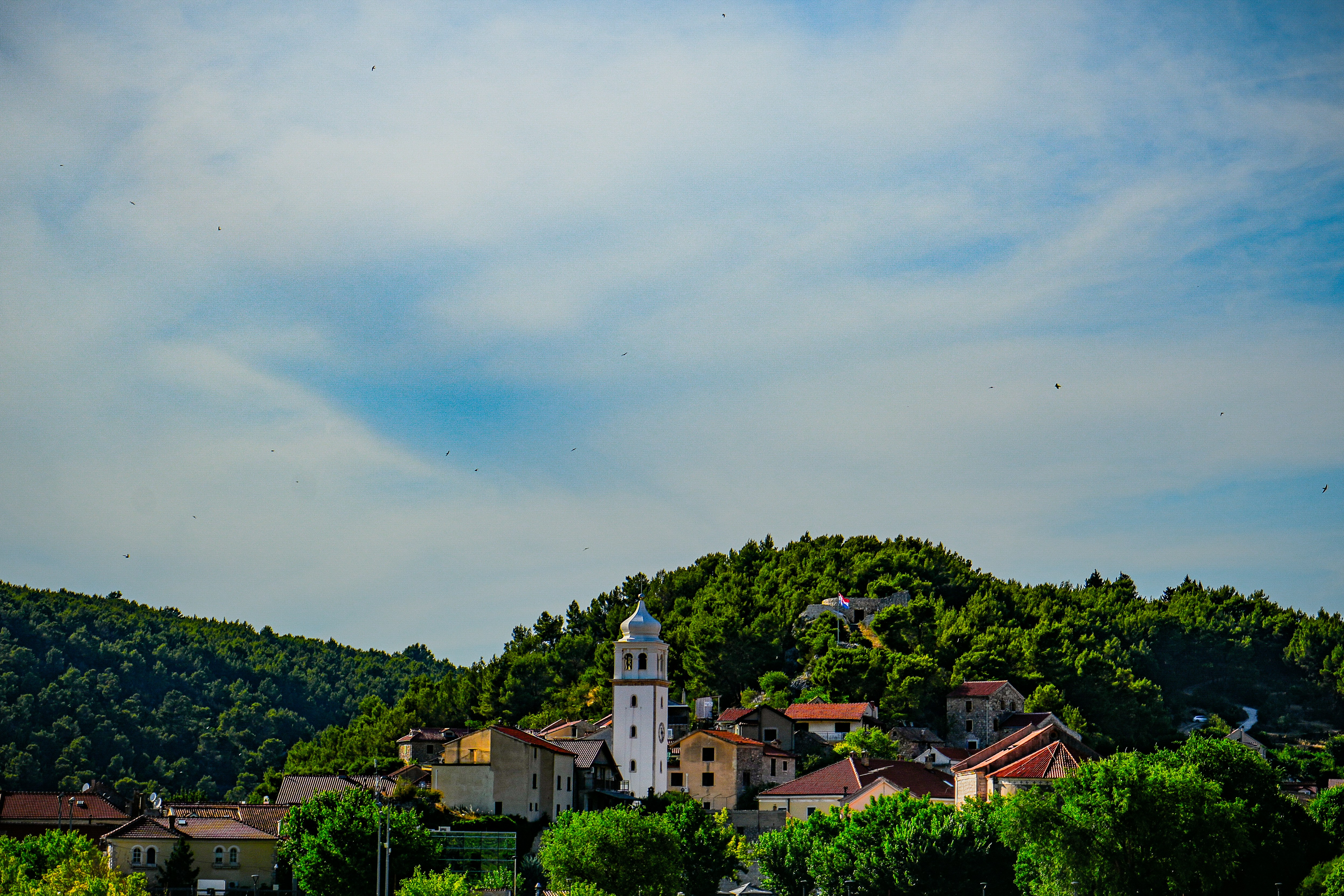 A small european village sits under a cloudy sky.