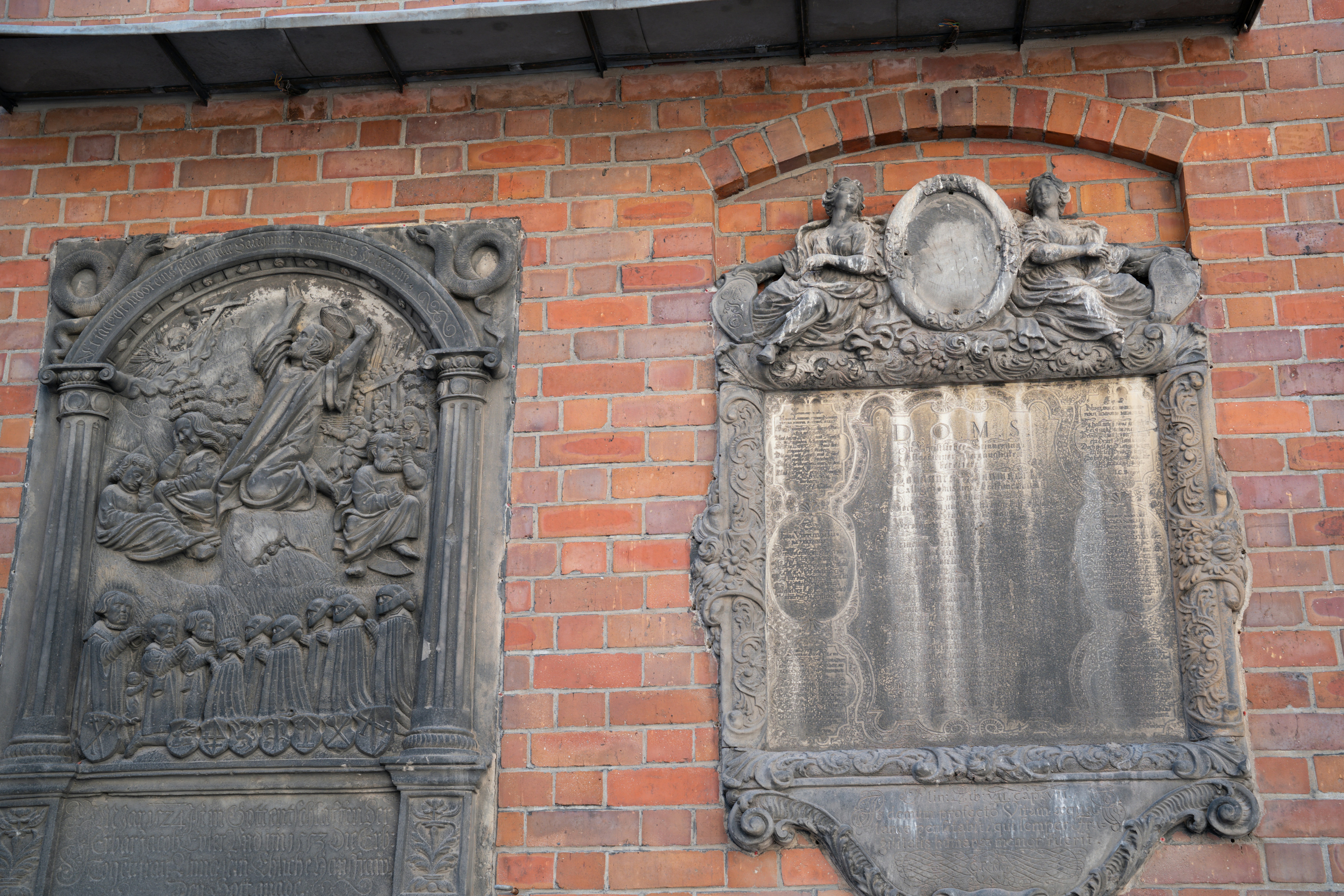Two ornate stone plaques are affixed to a brick wall. photo – Free ...