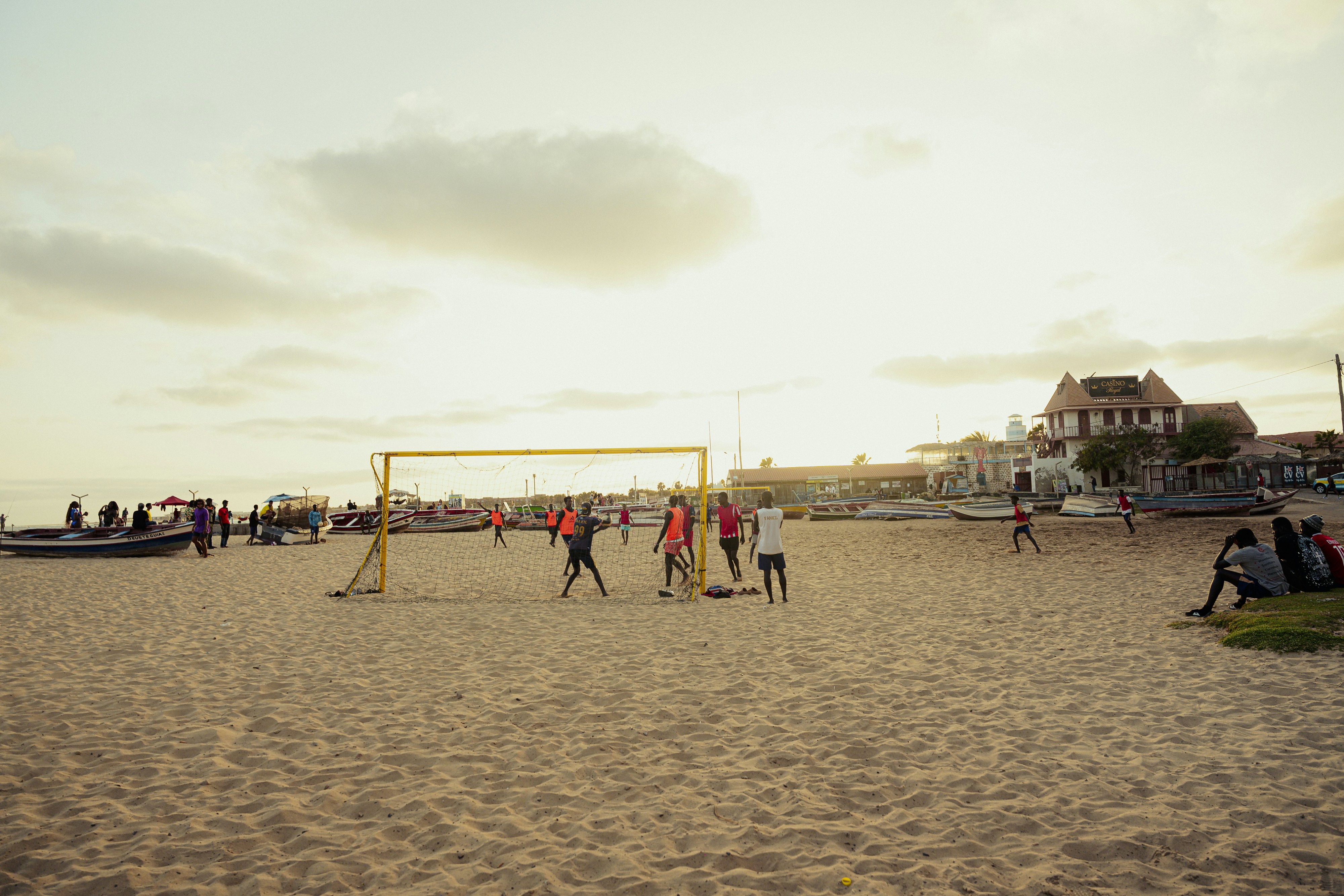 Cape Verde is more than beaches — it’s about people, tradition, and stories told by the sea. This frame from Sal captures the harmony between man, land, and ocean. | People are playing soccer on a sunny beach.