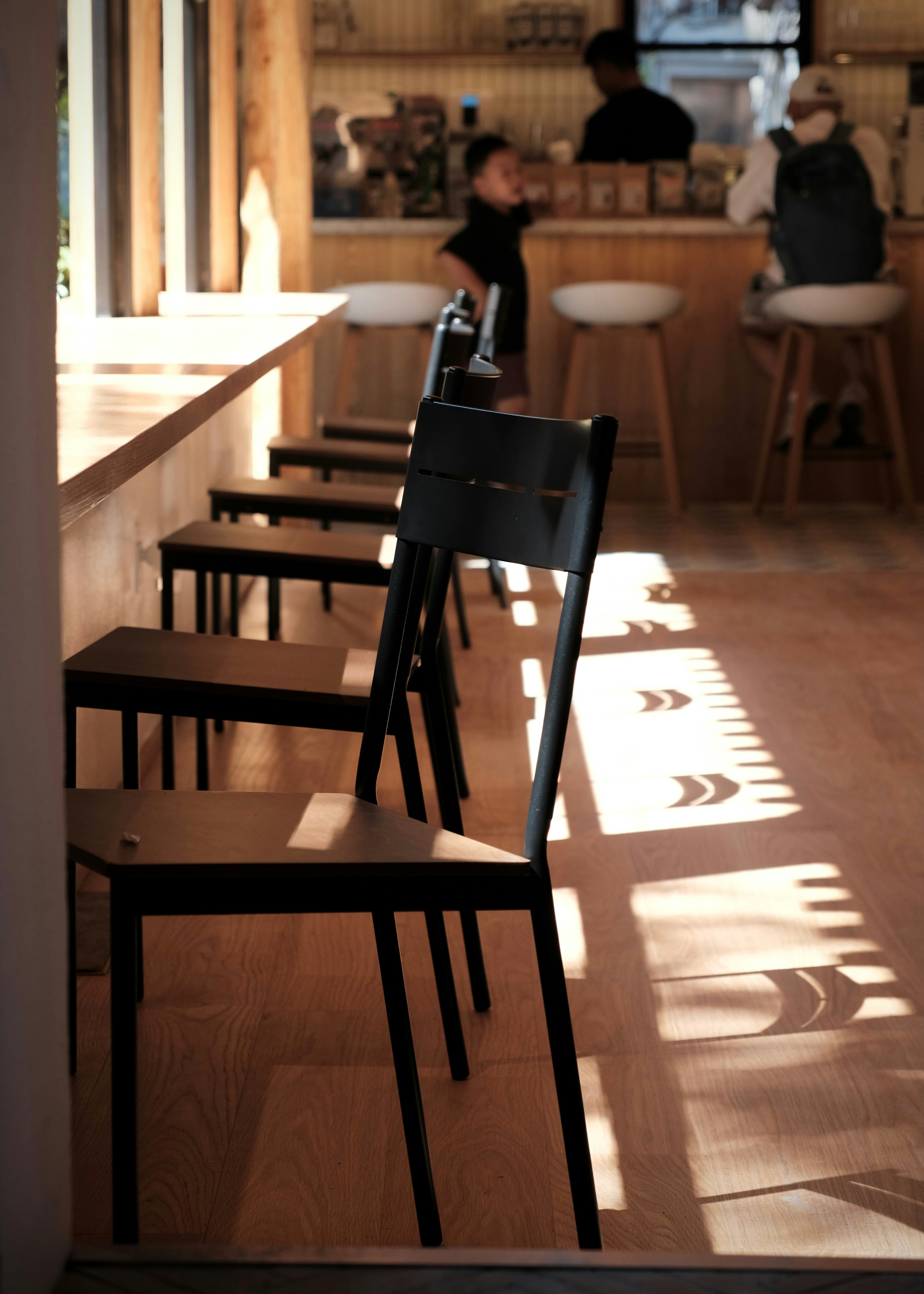 Empty chairs and people enjoying a cafe.