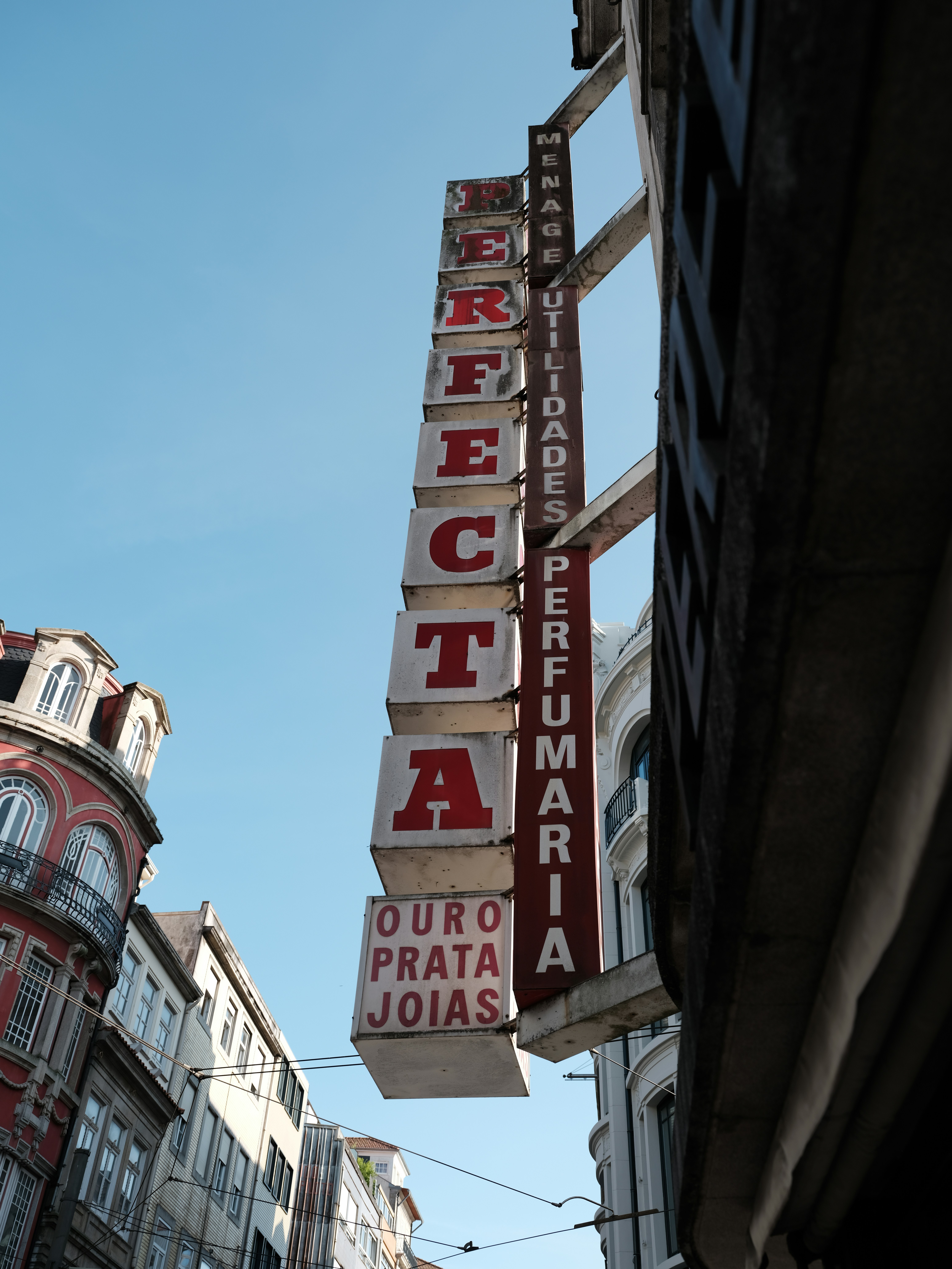 An old store sign hangs from a building.