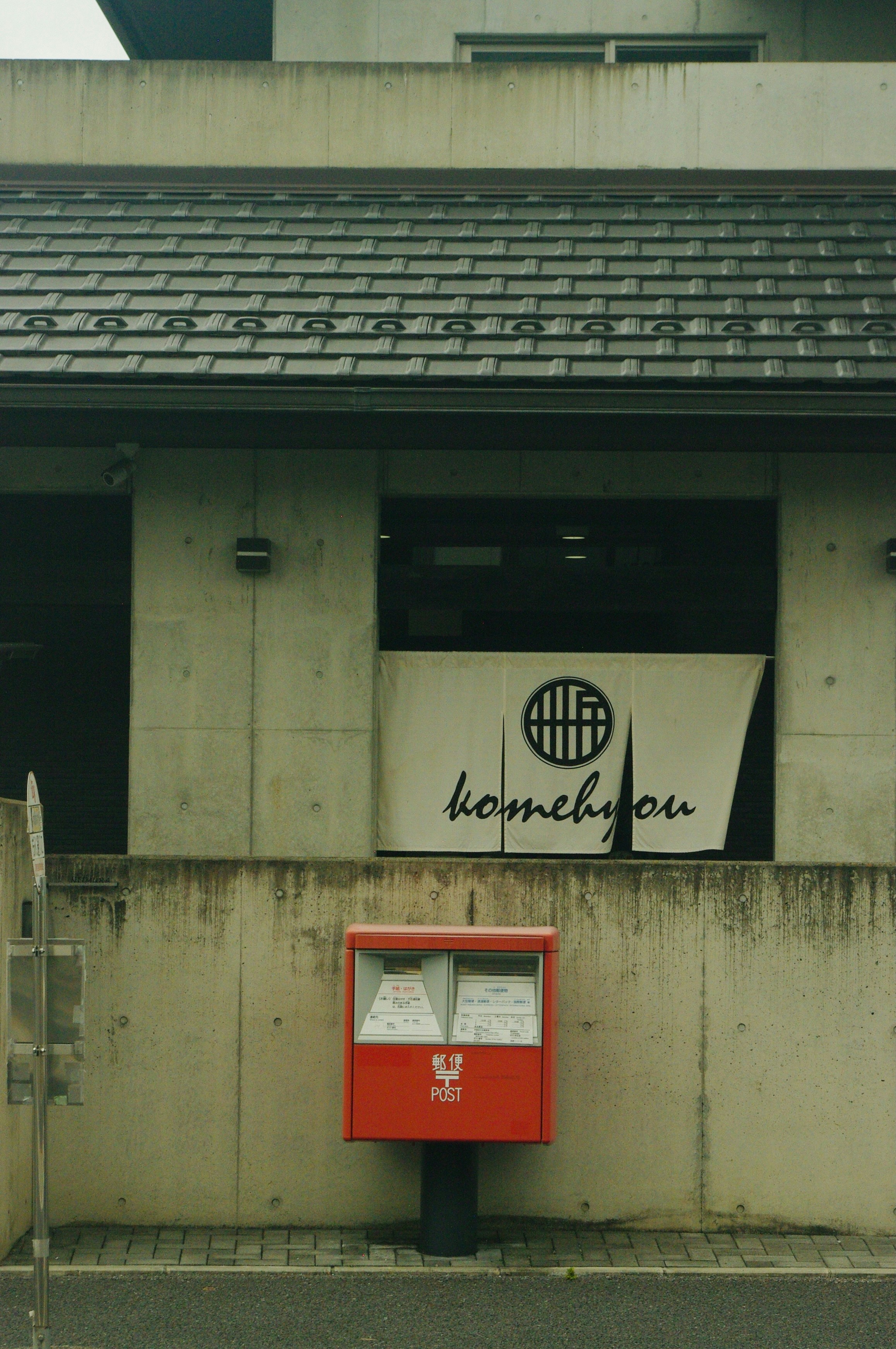 A red mailbox stands in front of a store. photo – Free Building Image ...