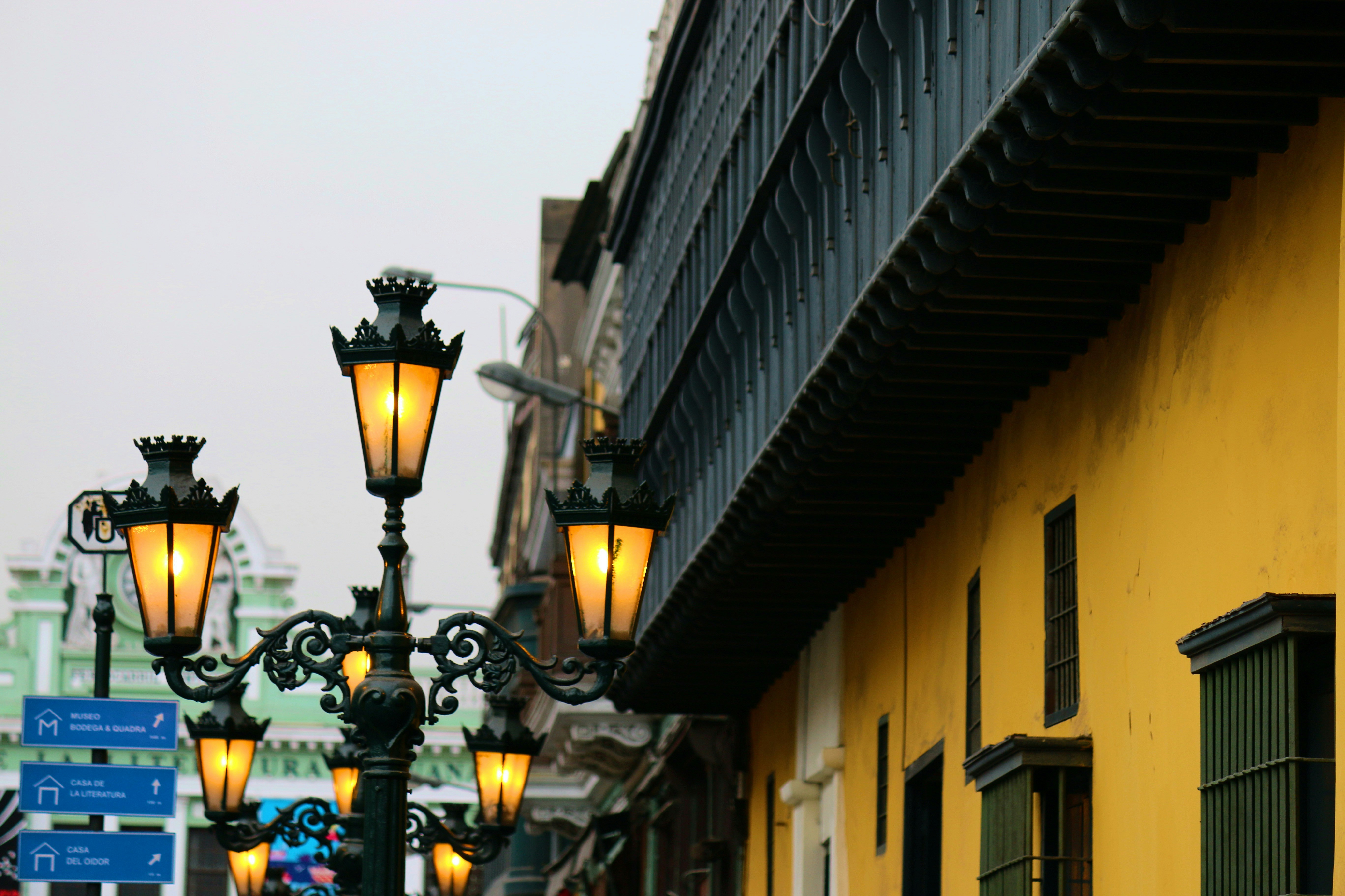 Decorative street lamps stand by a colorful building.