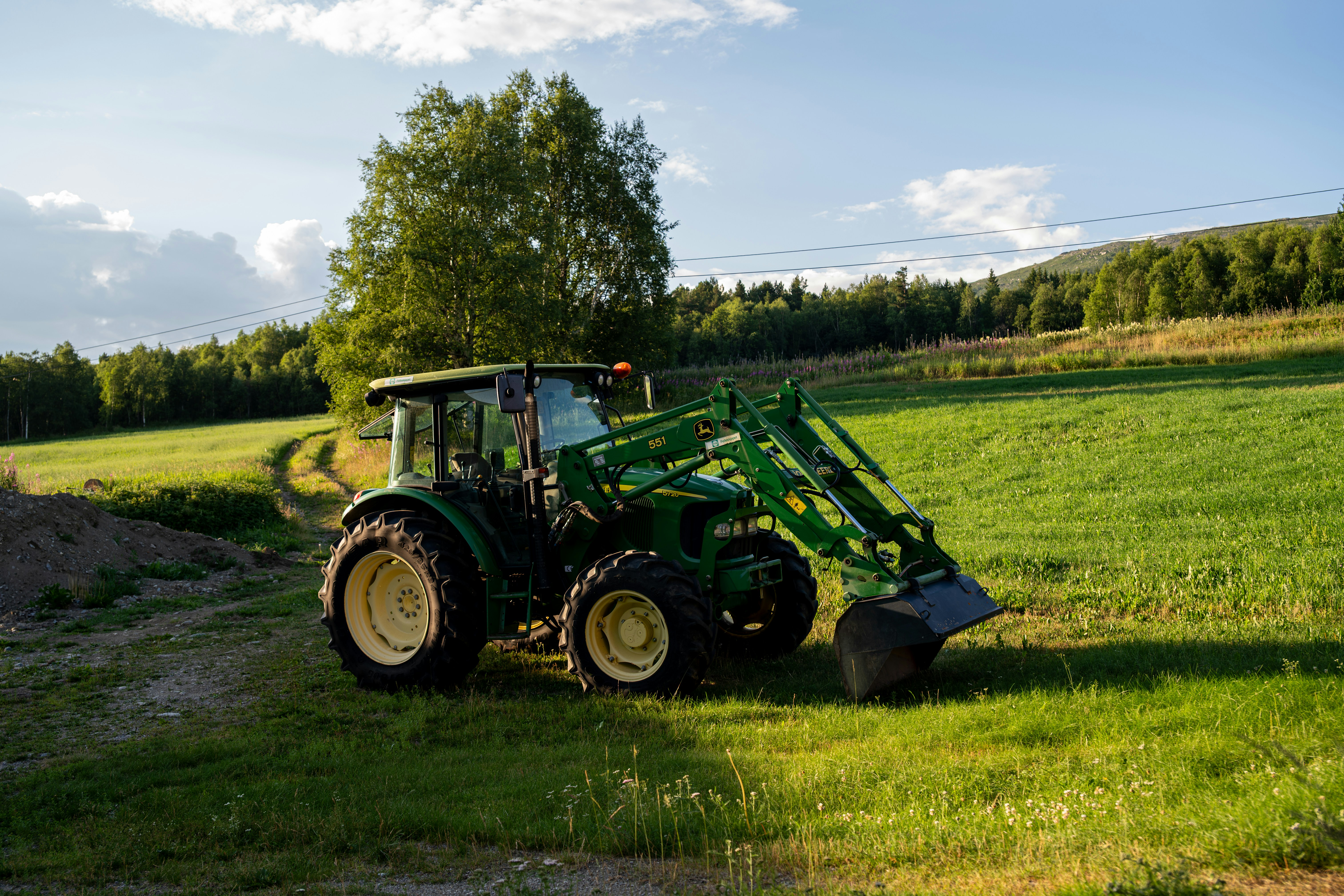 A green tractor sits in a grassy field.