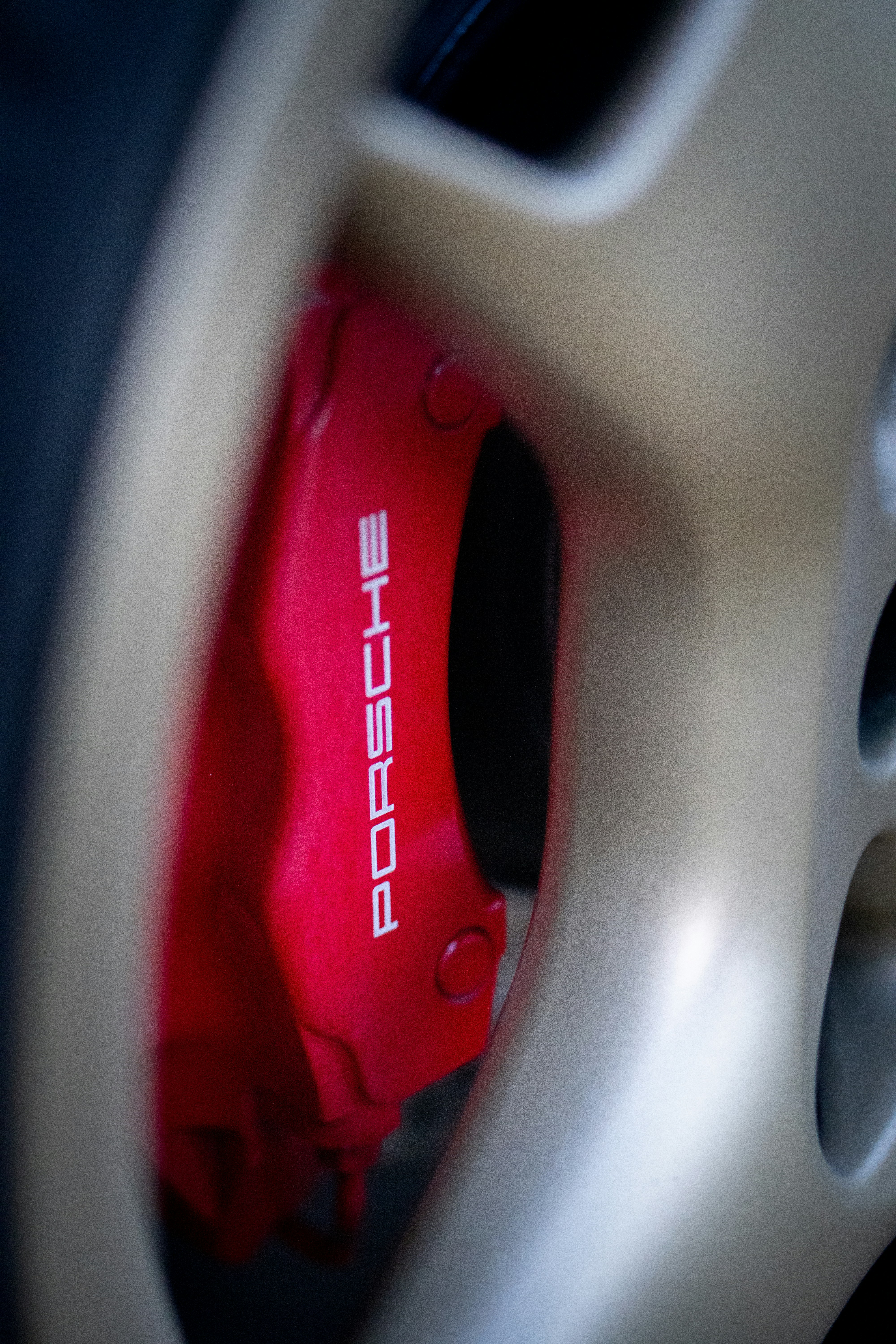A porsche brake caliper with red paint.