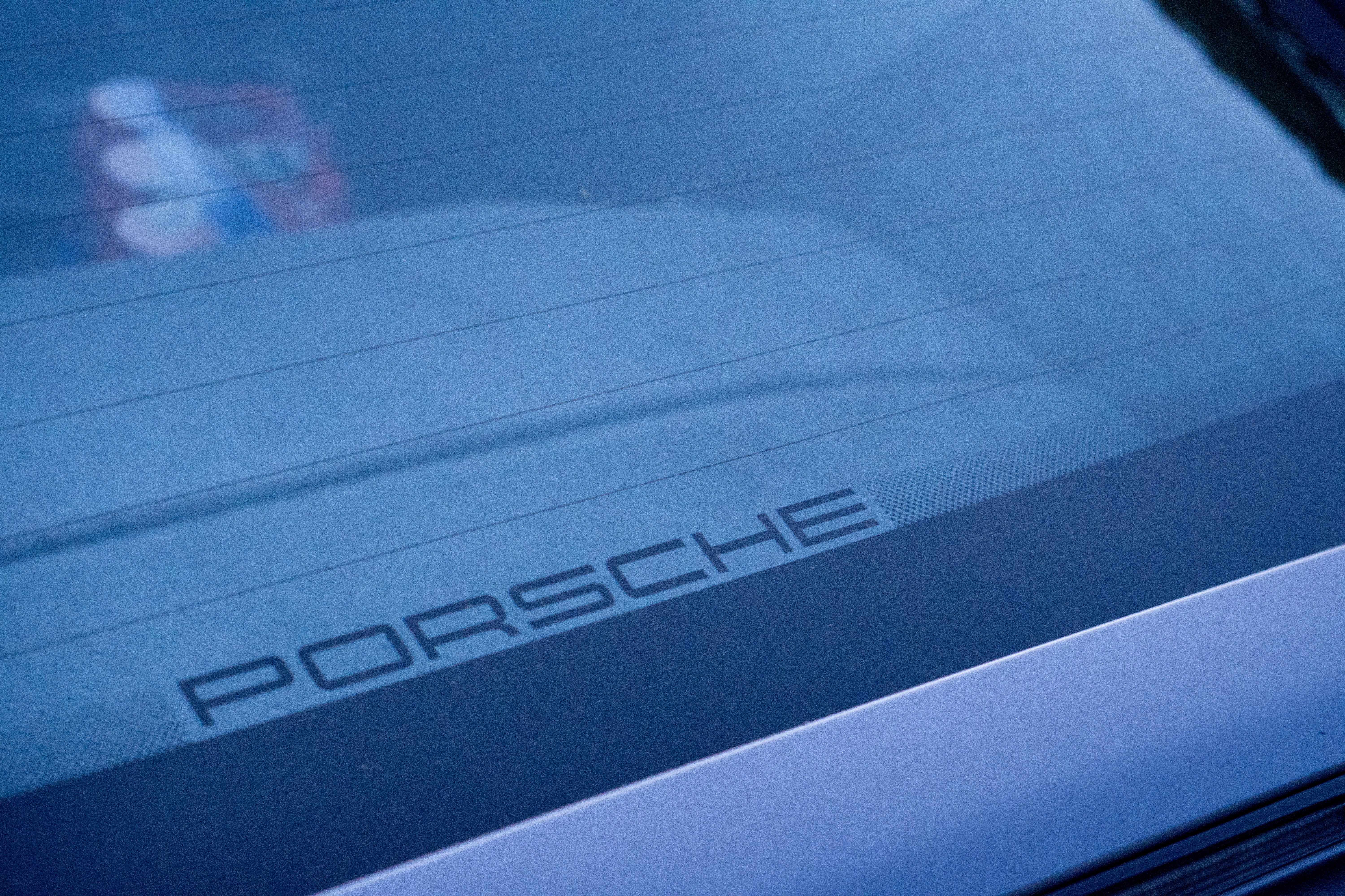 Porsche logo on a car window.
