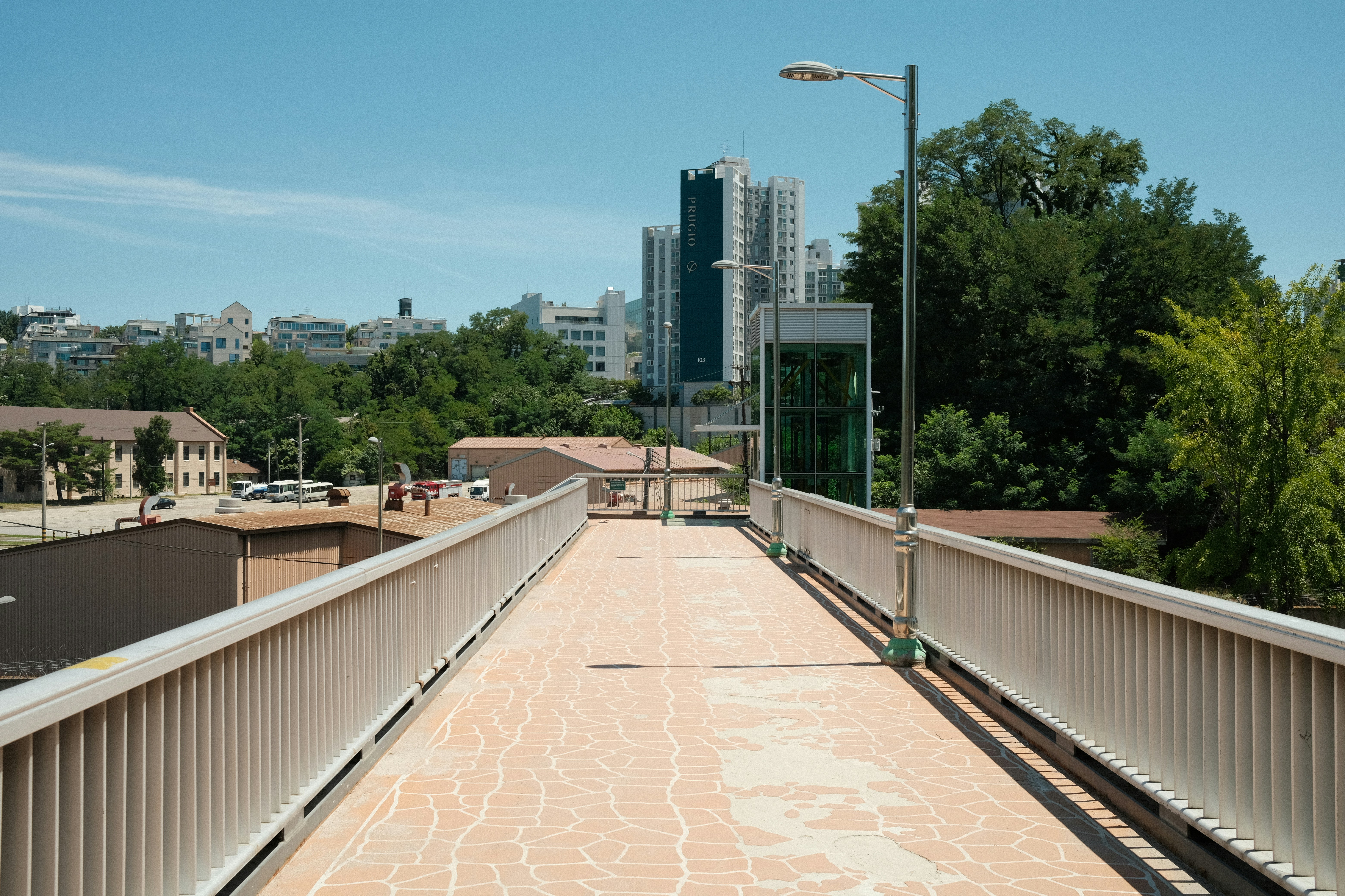 A bridge leads into a cityscape on a sunny day.