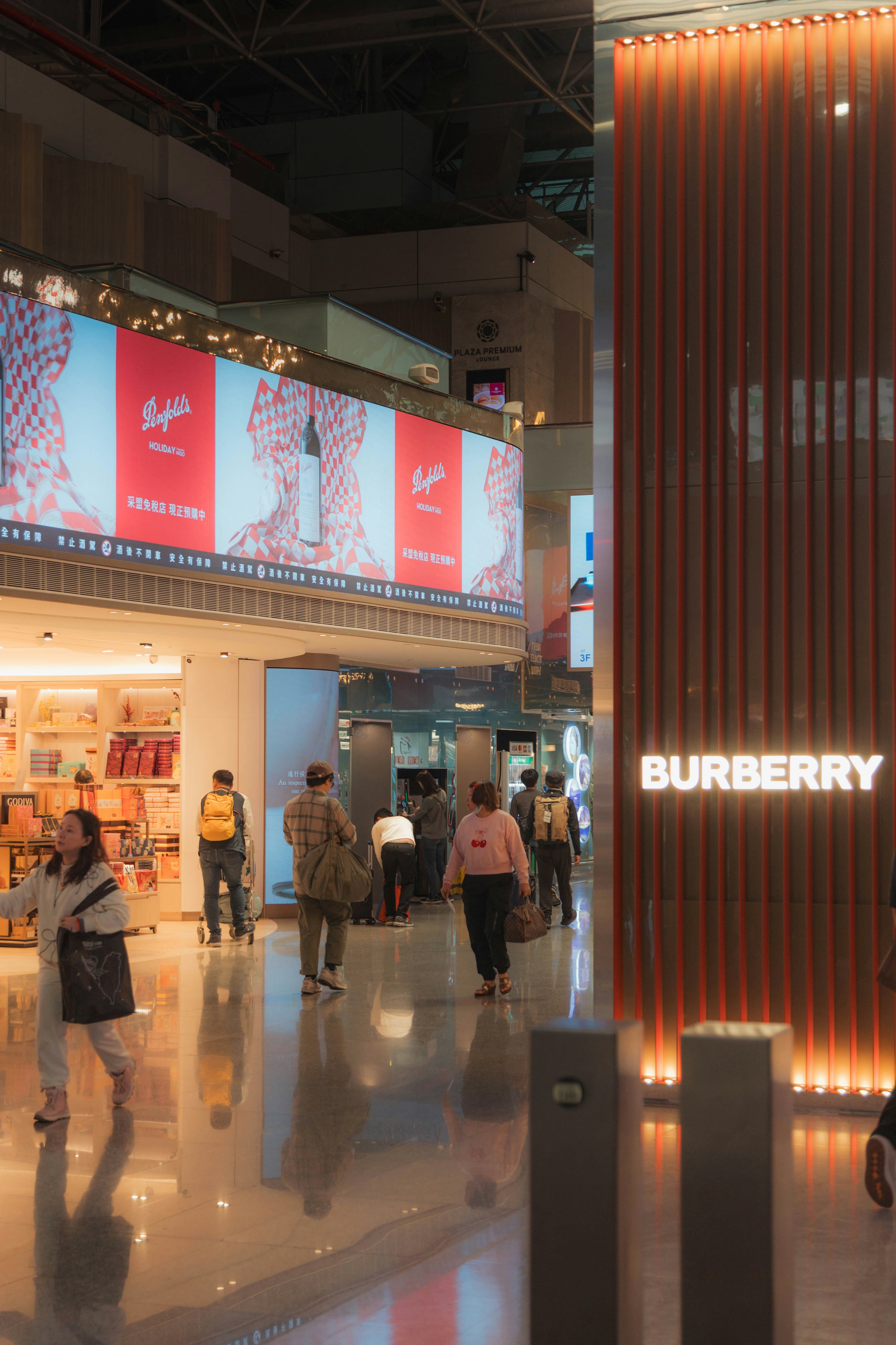 People walk by a burberry store in an airport.
