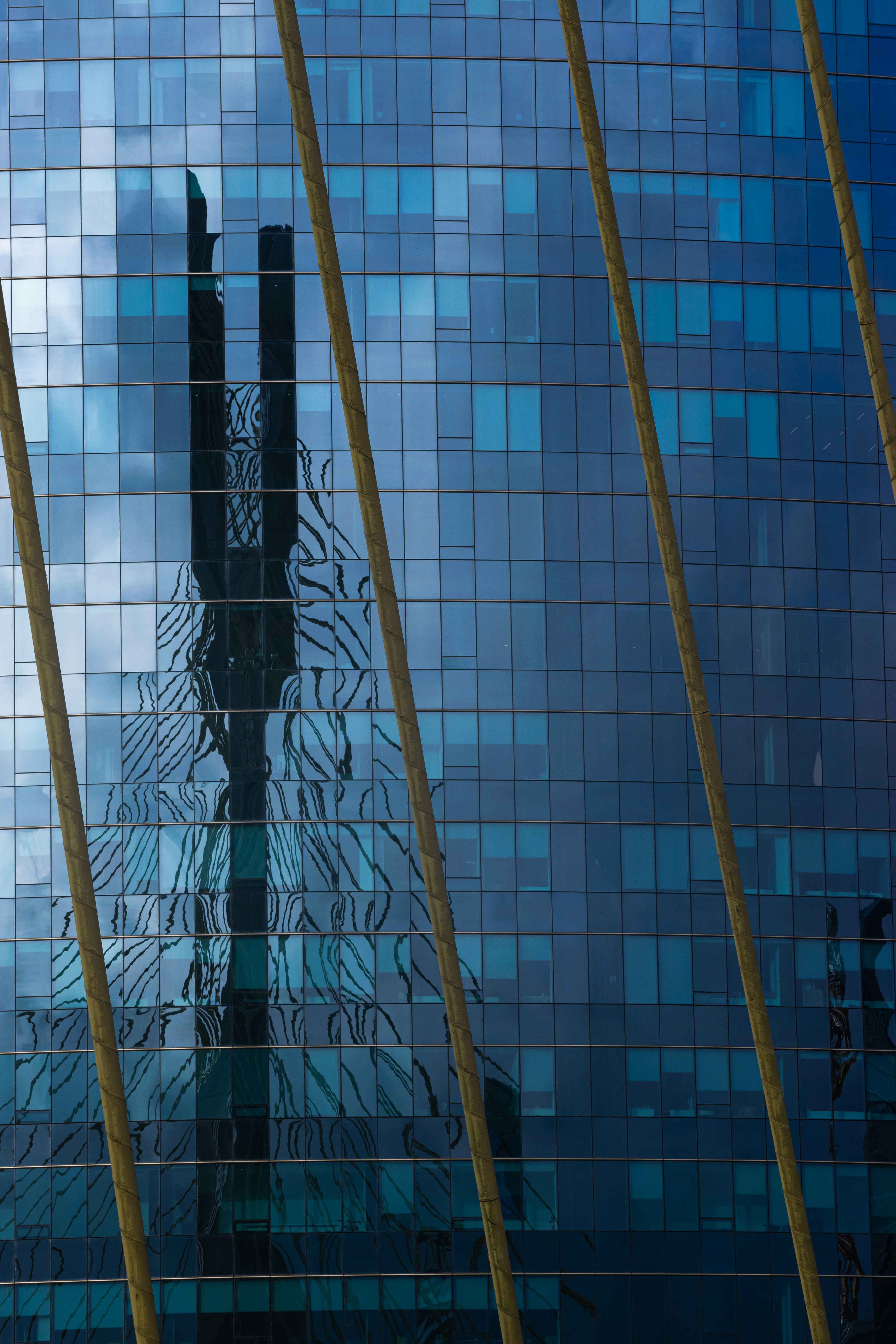 Octavio Frias de Oliveira Bridge (locally known as Ponte Estaiada) reflected in a mirrored building. São Paulo, Brazil, Mar/20. | Reflections distort on a modern glass building.