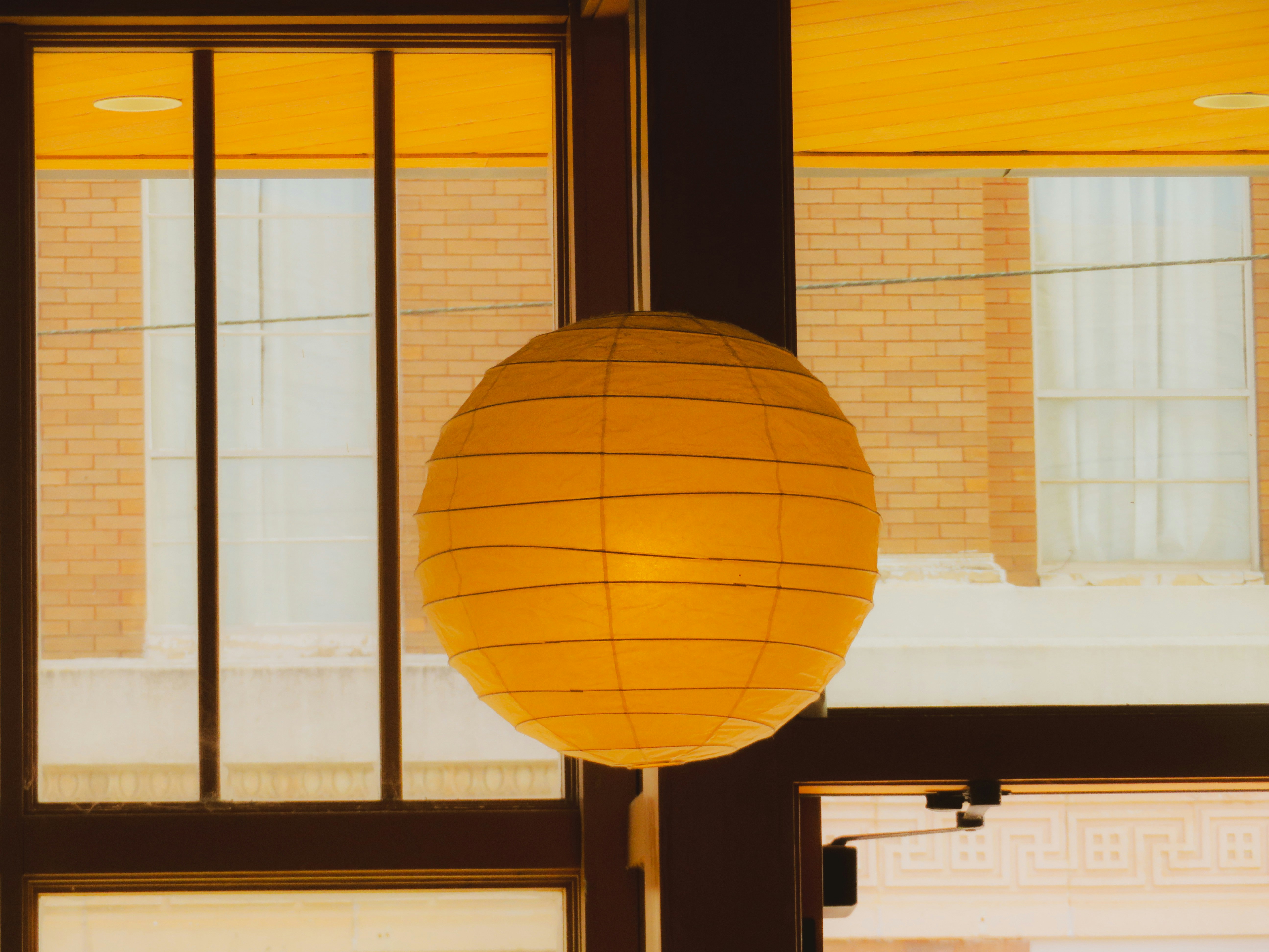 A yellow paper lantern hangs near a window.