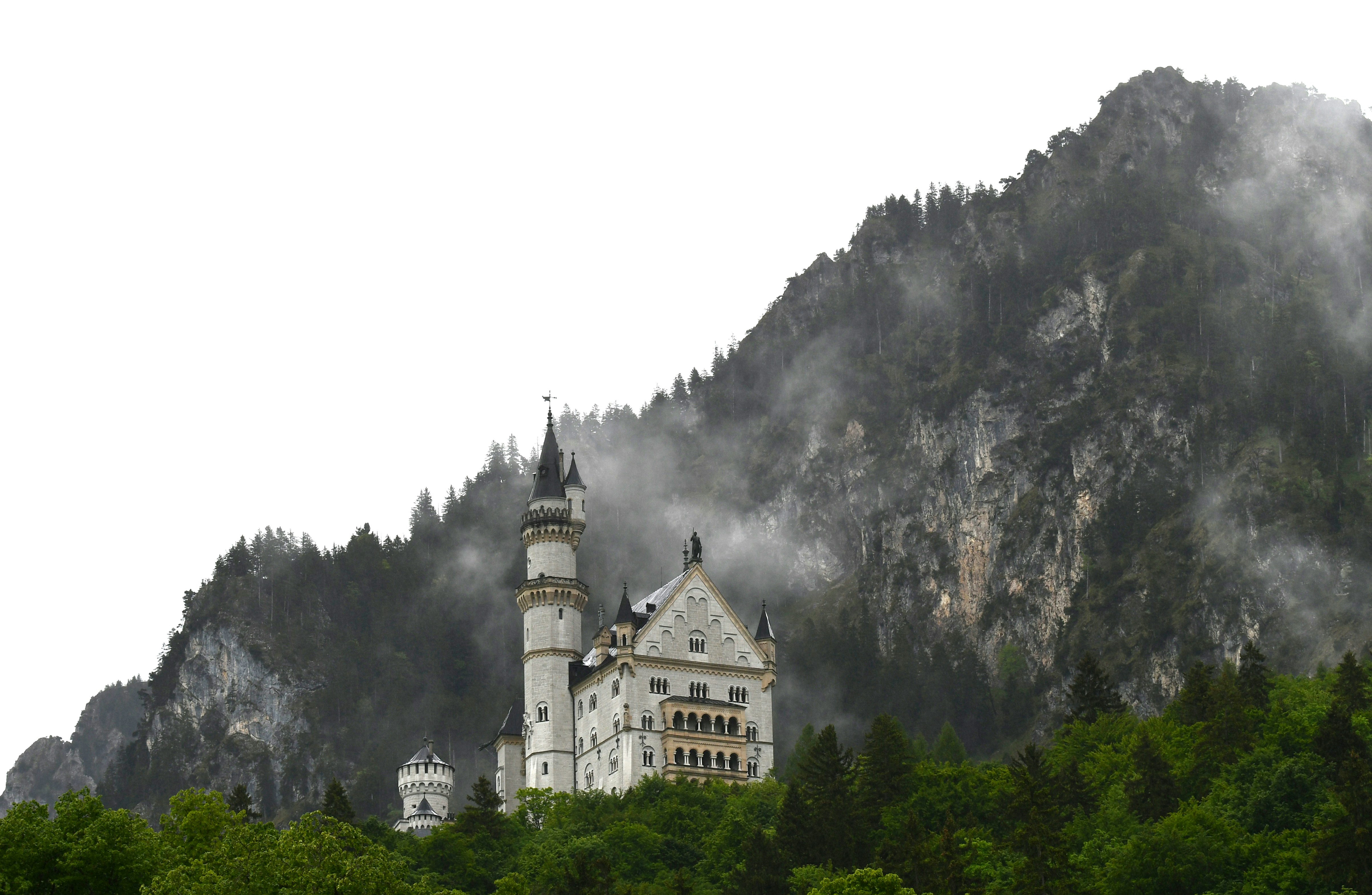 A castle sits below a misty mountain.