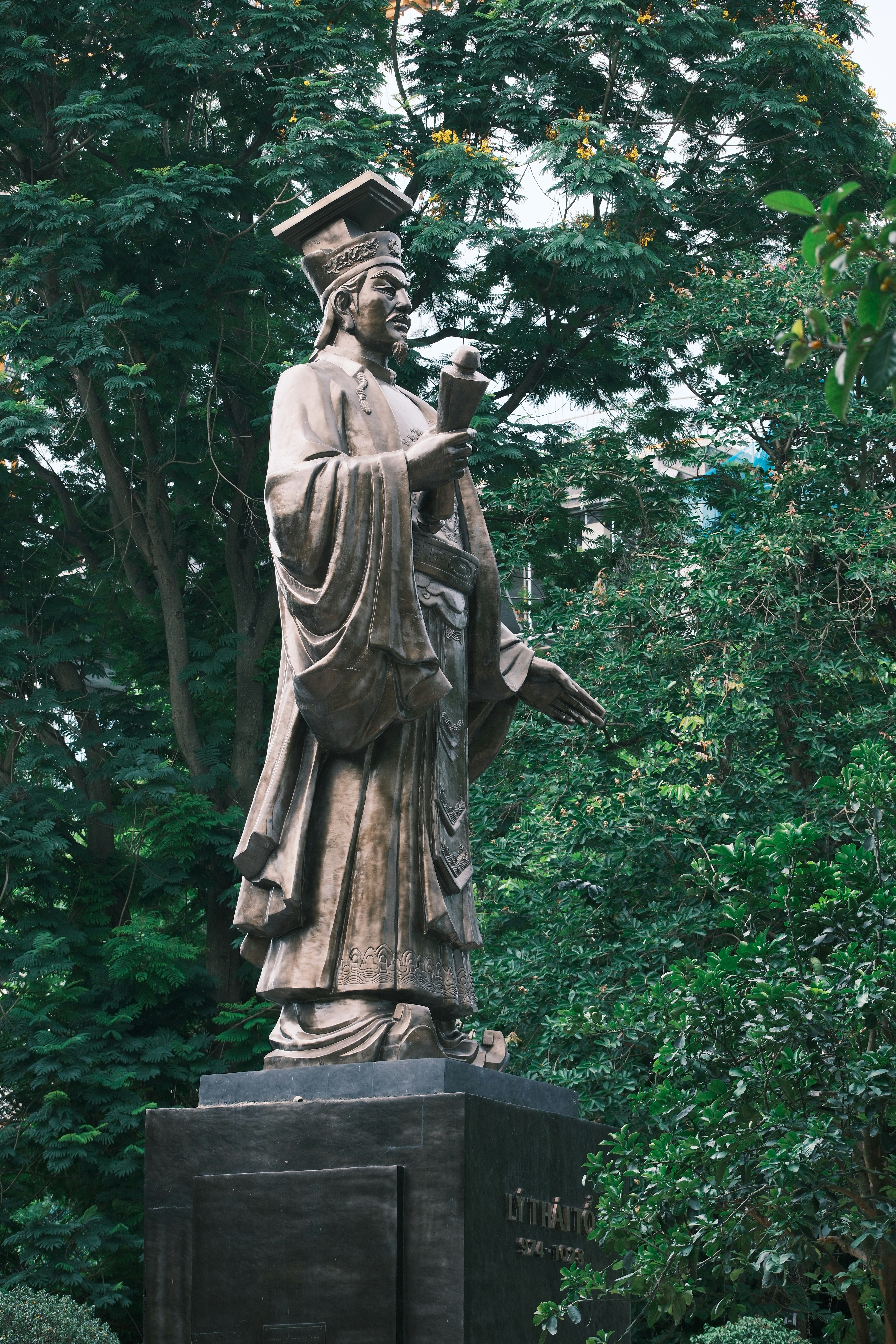 A statue of a man stands in a park.