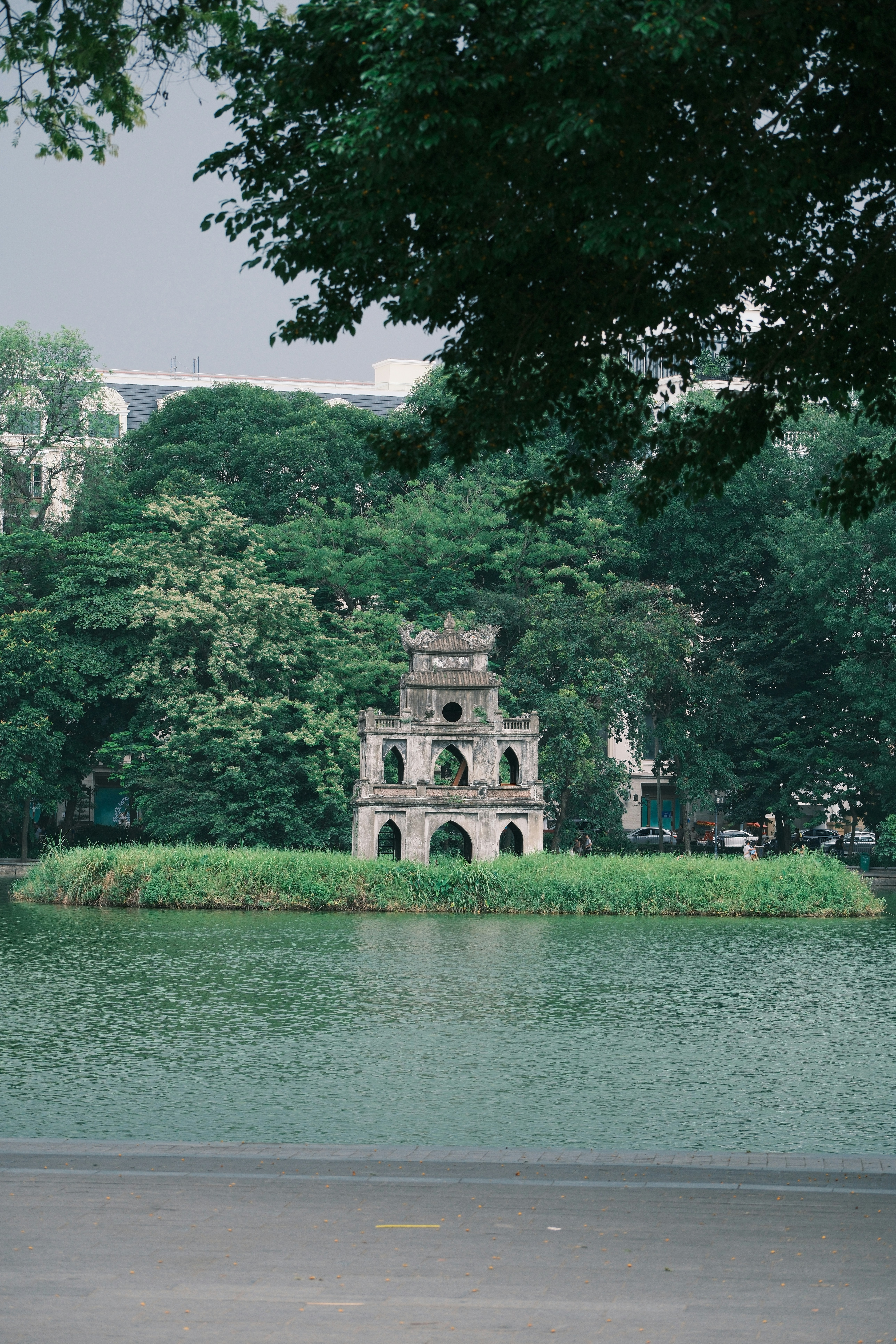 A stone tower stands in the middle of a lake.