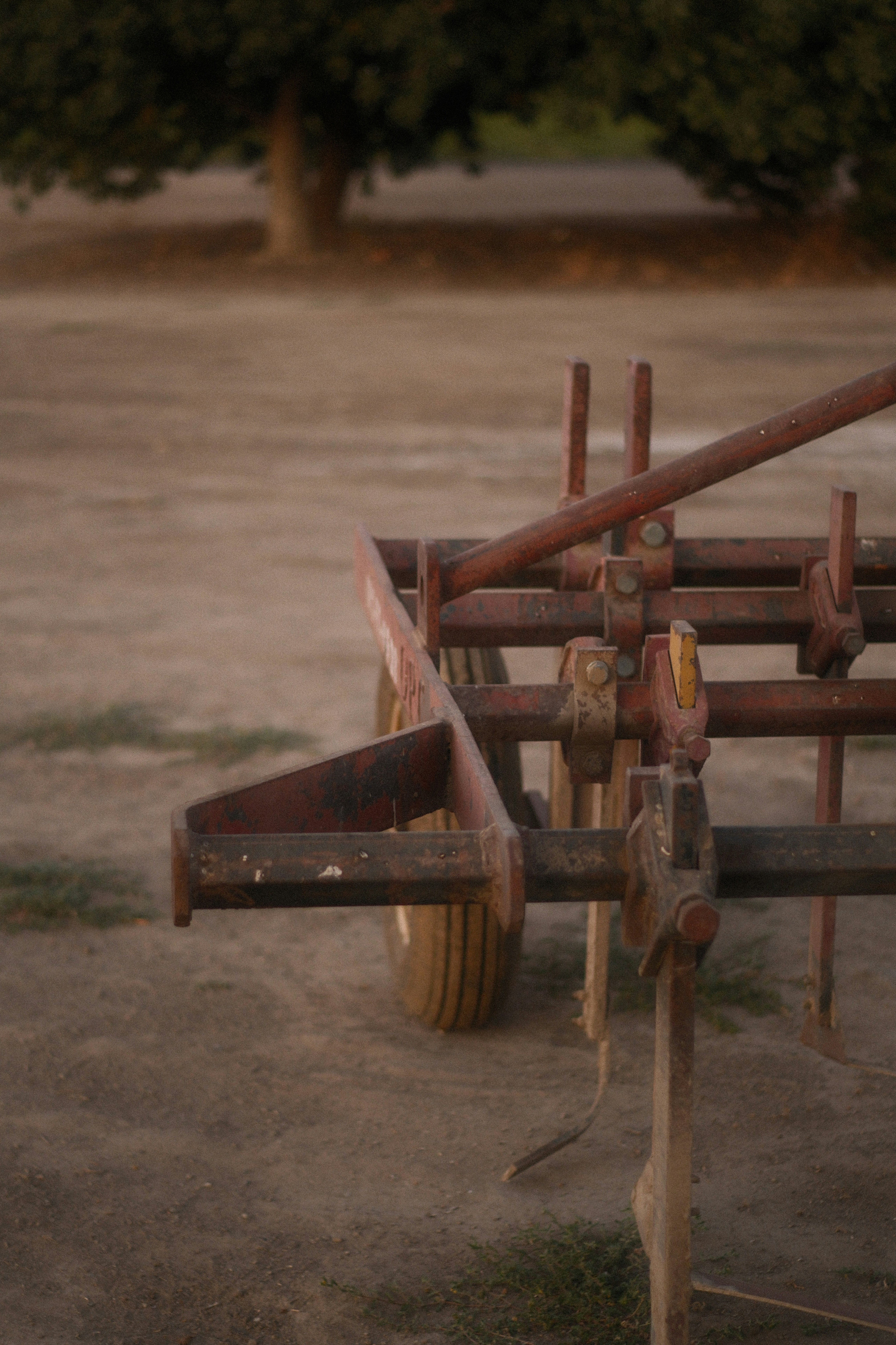 A farm implement rests in a field.