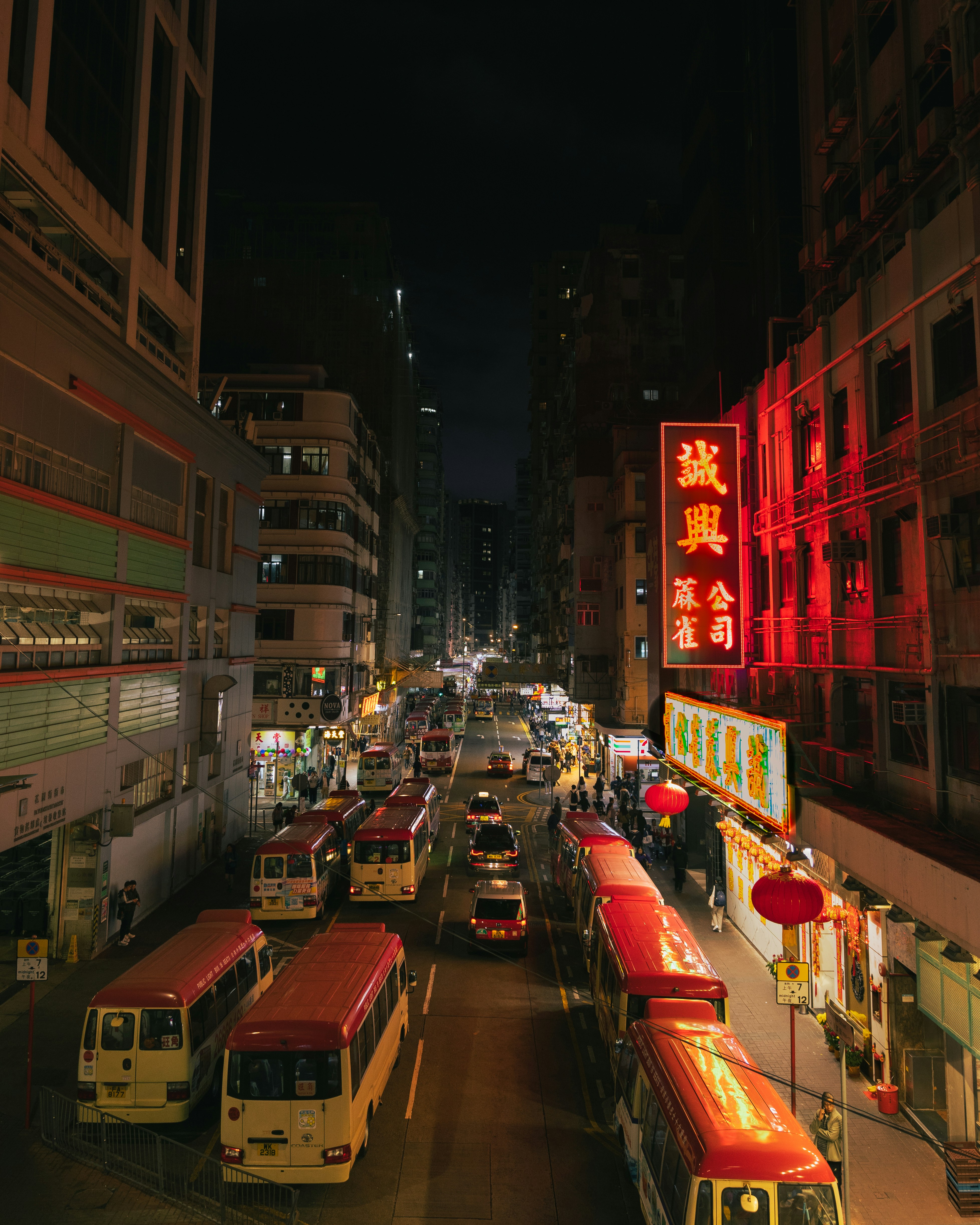 Iconic view in Hong Kong. | Buses and cars fill a busy city street at night.