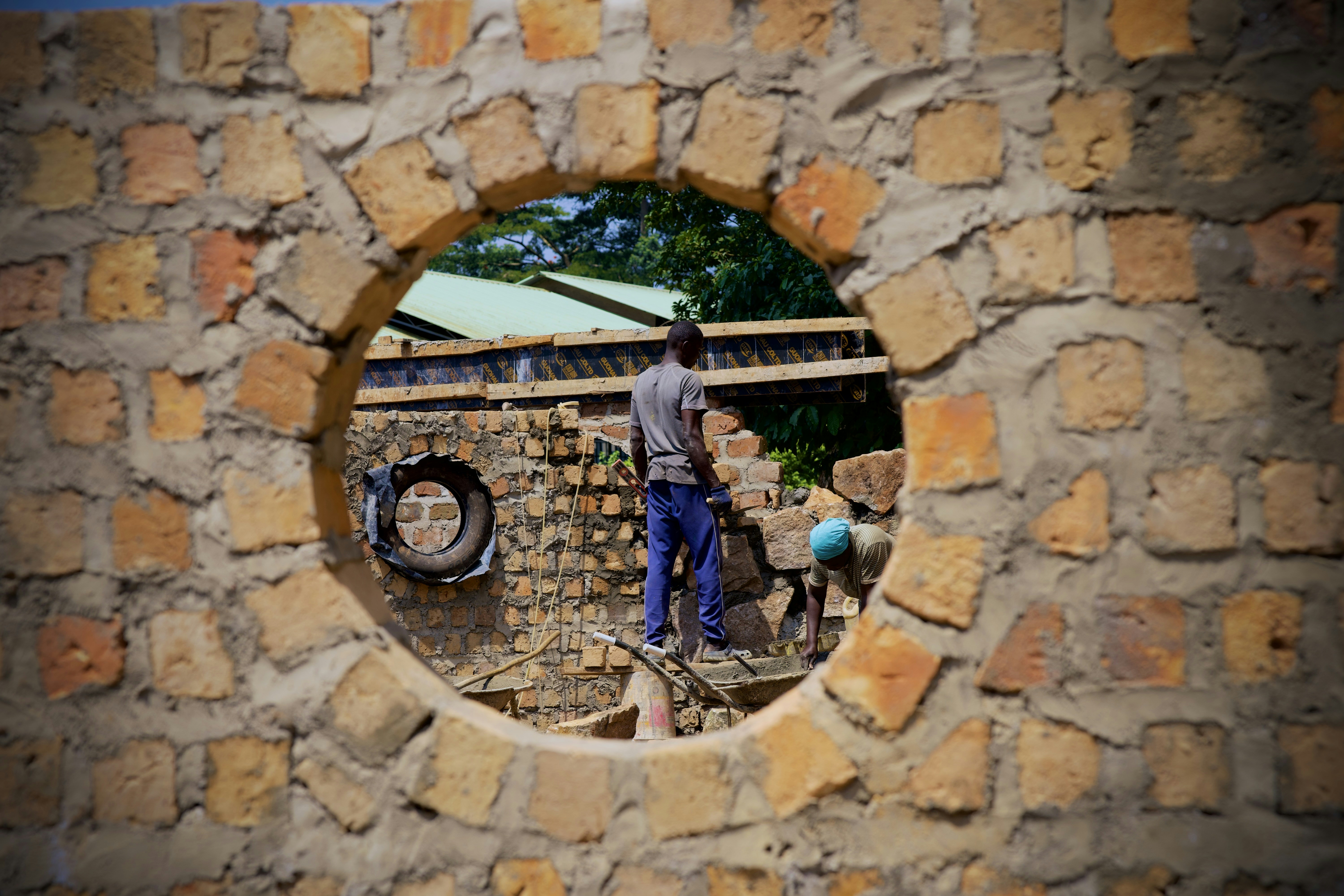 Circular View through Brick Ring Reveals Workers at a Construction Site