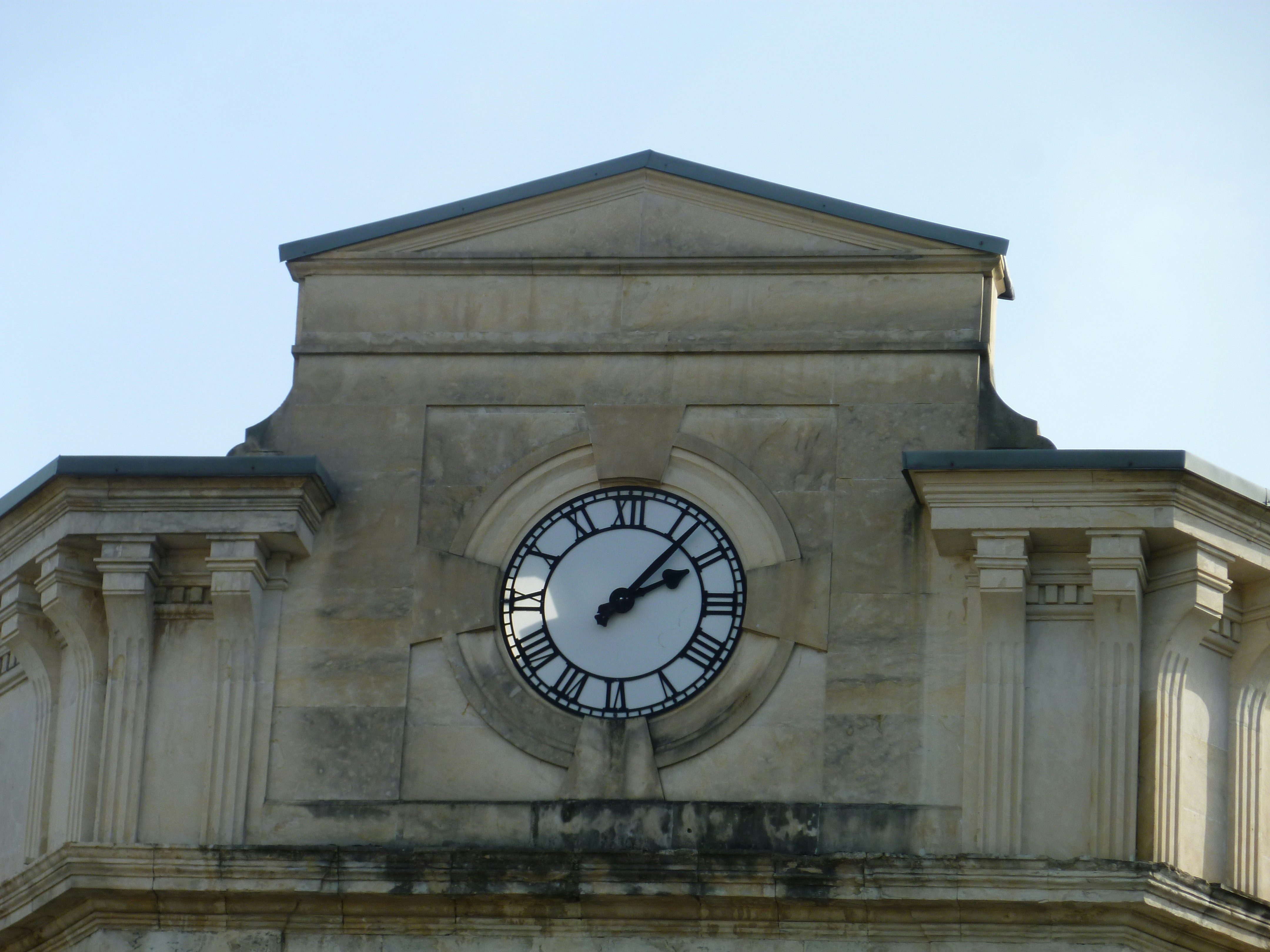 An old clock is mounted on a building.
